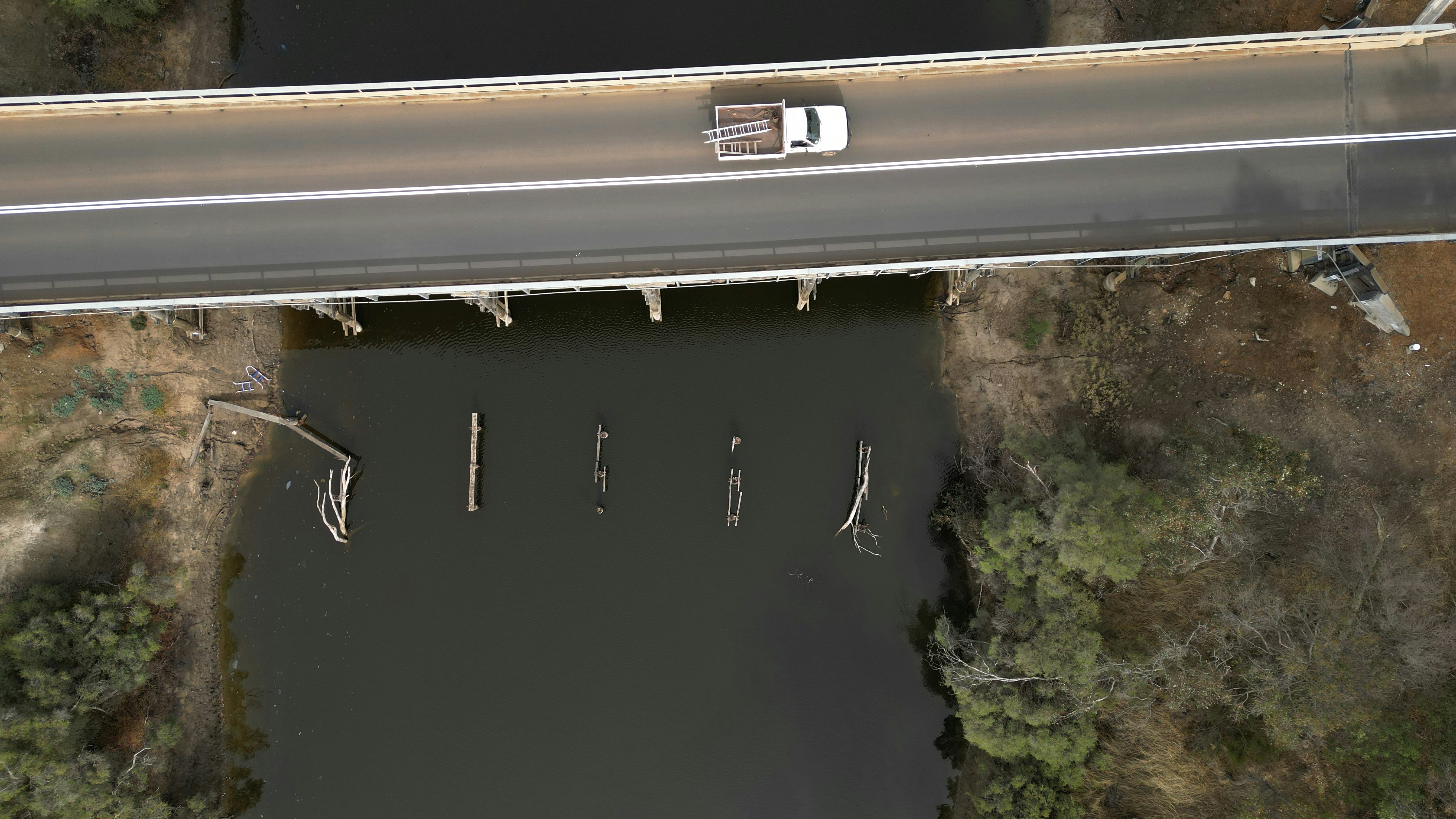 White Truck on a Narrow Riverside Bridge — Quiet Currents Beneath a Slim Span