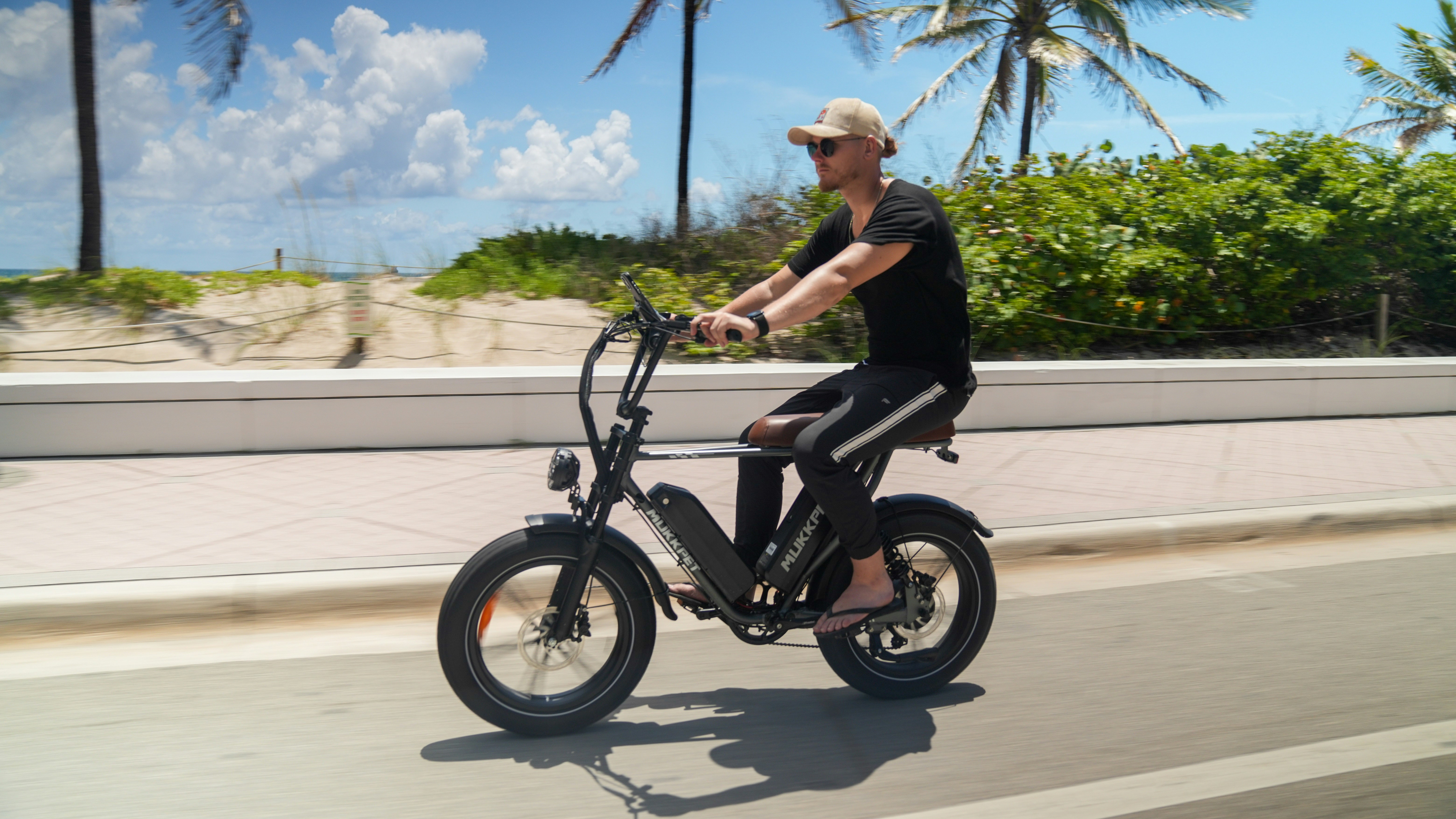 A man riding an electric bike down a street photo – Free Cycling Image ...