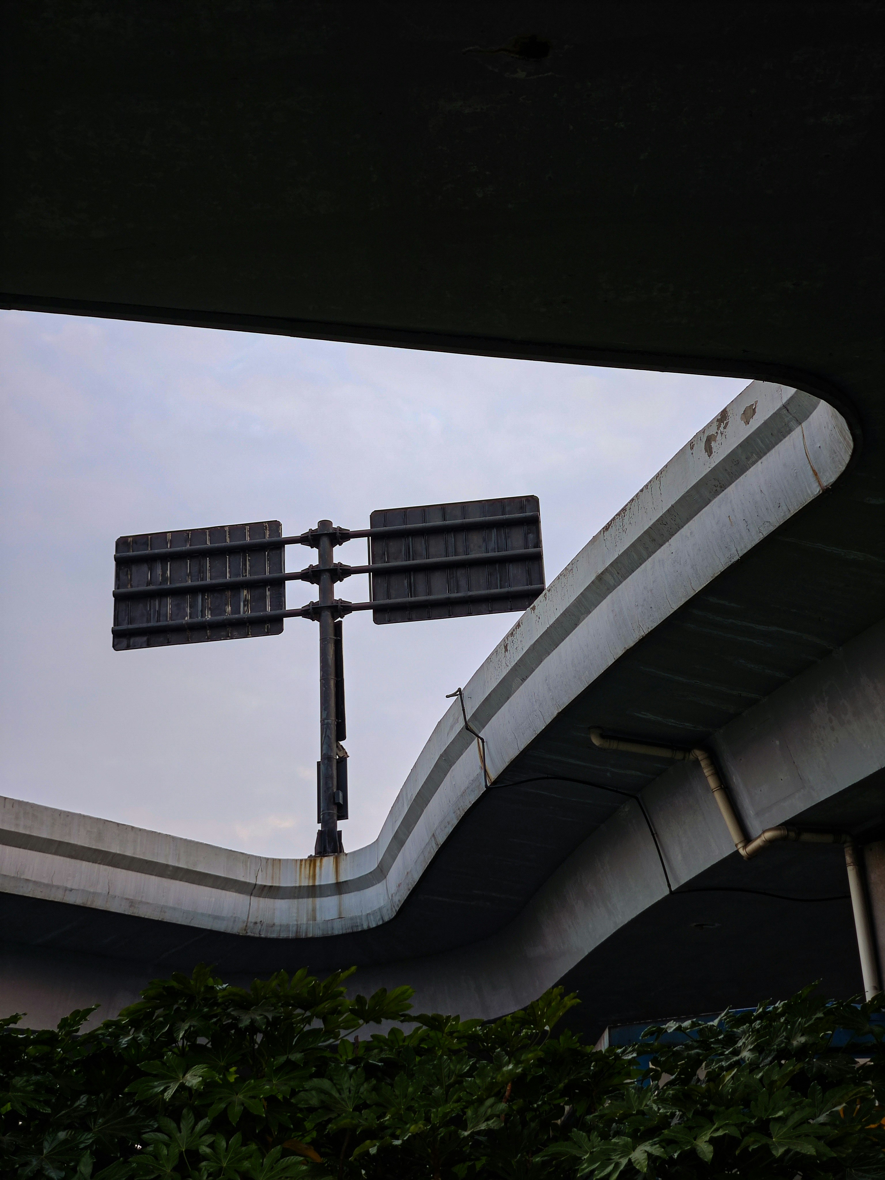A street sign on a metal pole under a bridge photo – Free Road Image on ...