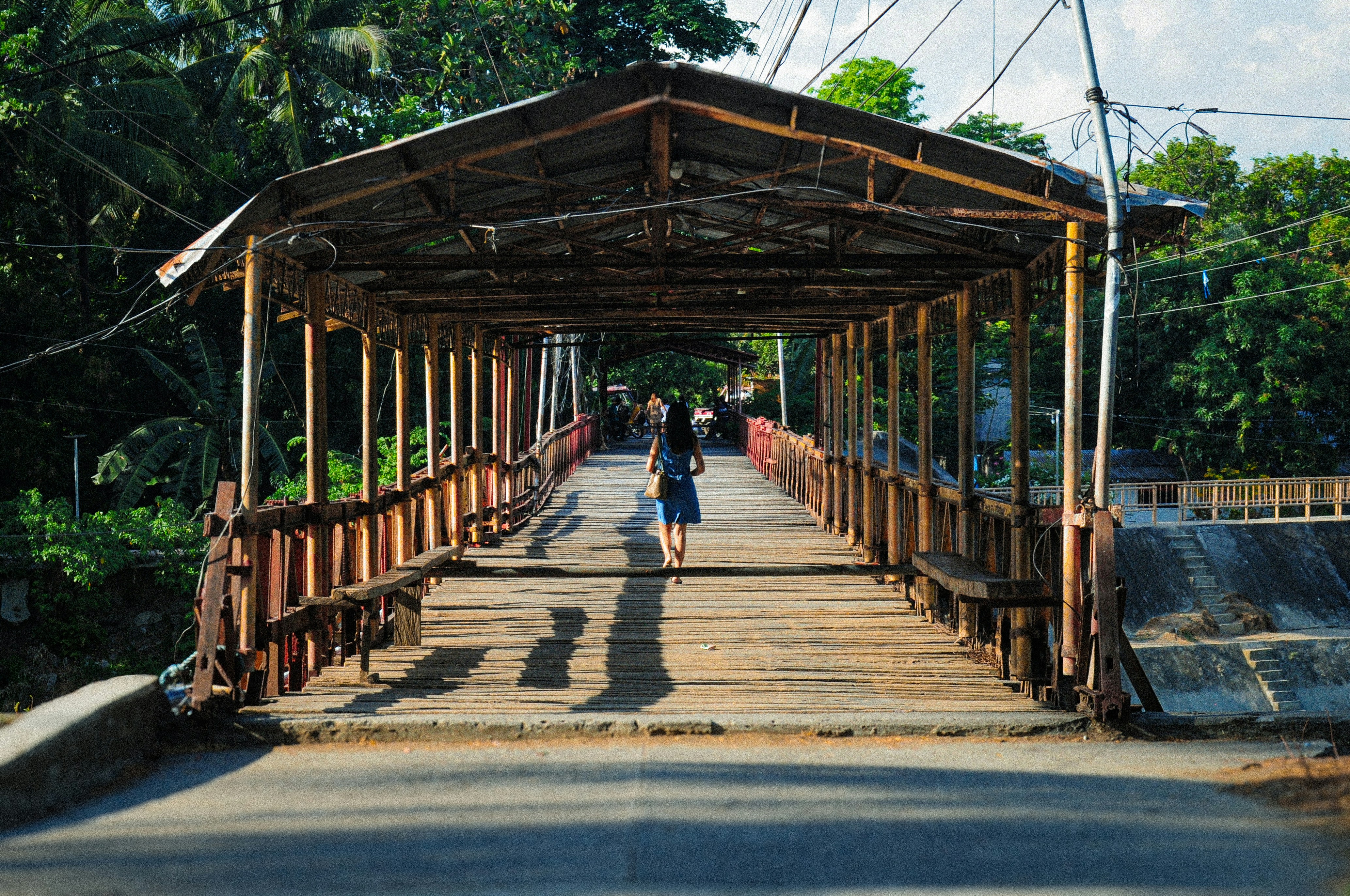 A couple of people walking across a wooden bridge photo – Free Bridge ...