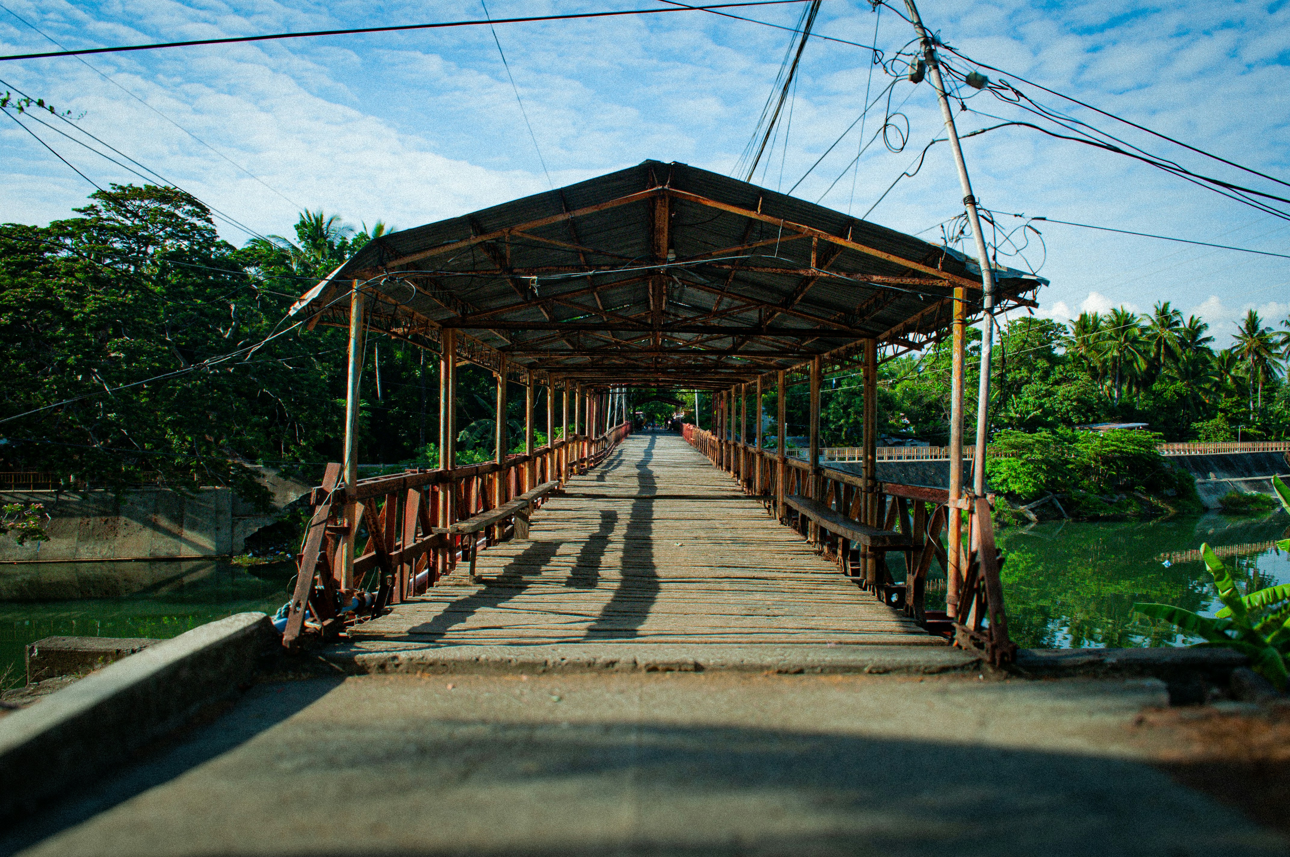 Old Bridge | a person walking across a wooden bridge over a river