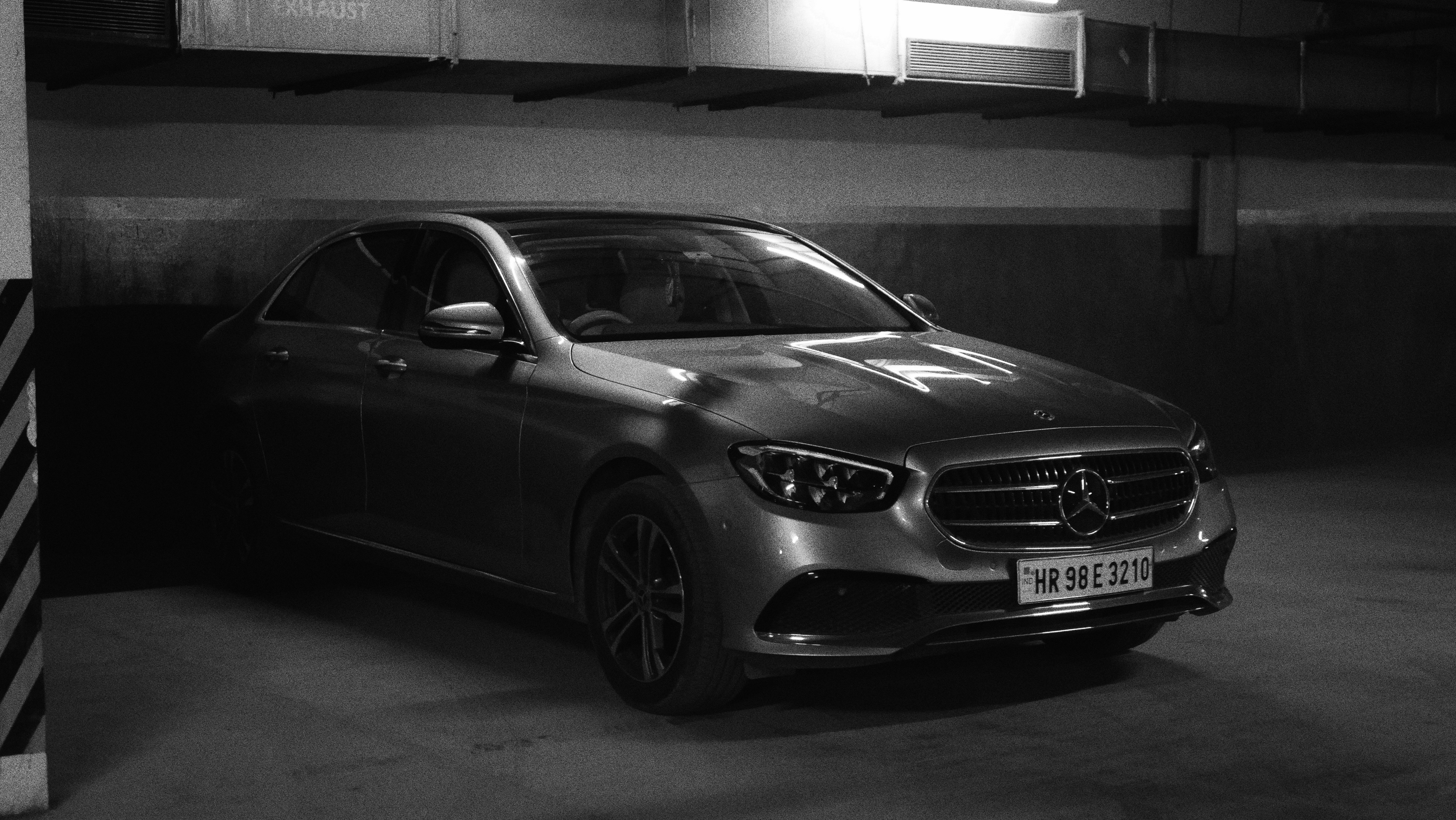 a black and white photo of a car in a parking garage