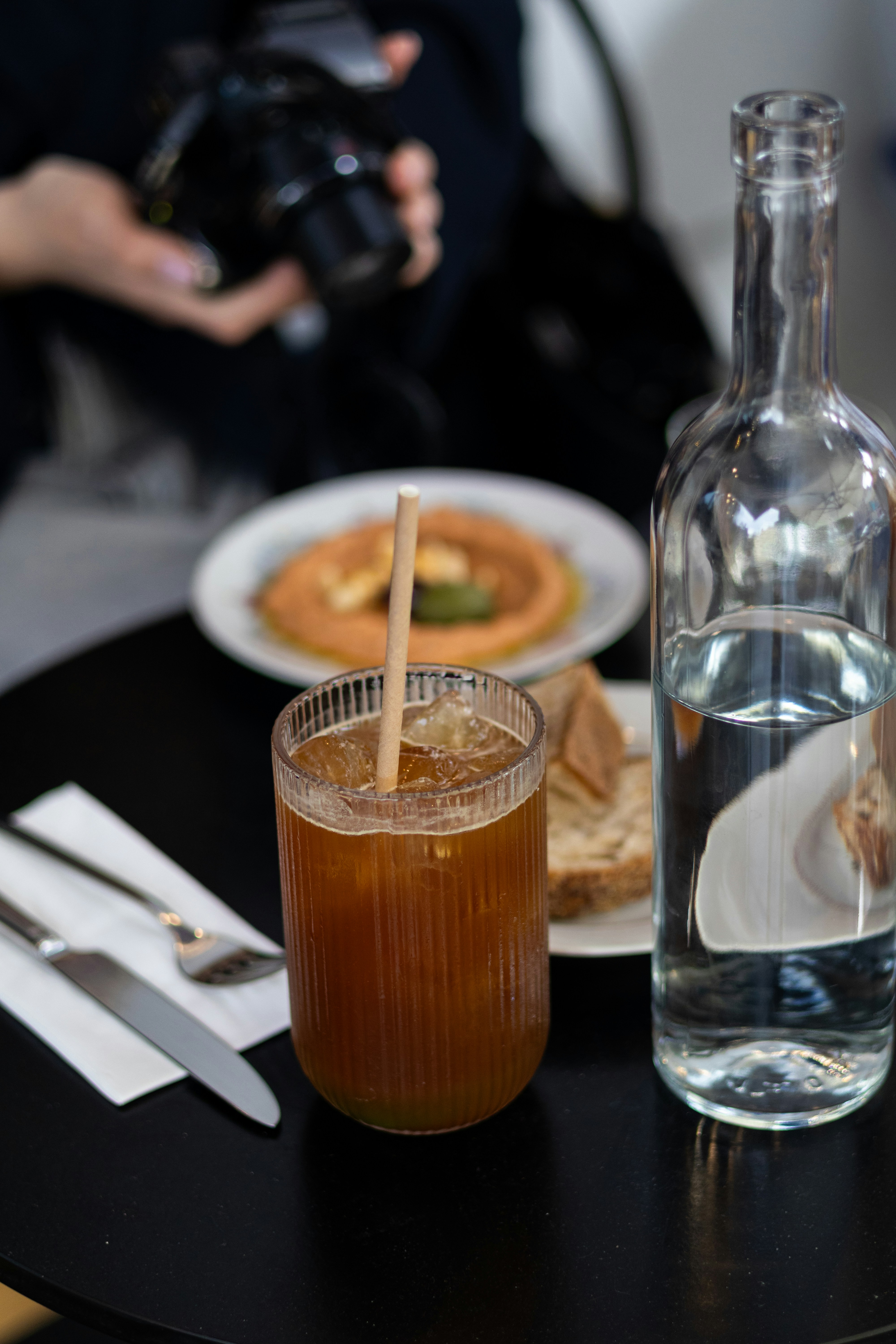 a table topped with a bottle of alcohol and a plate of food