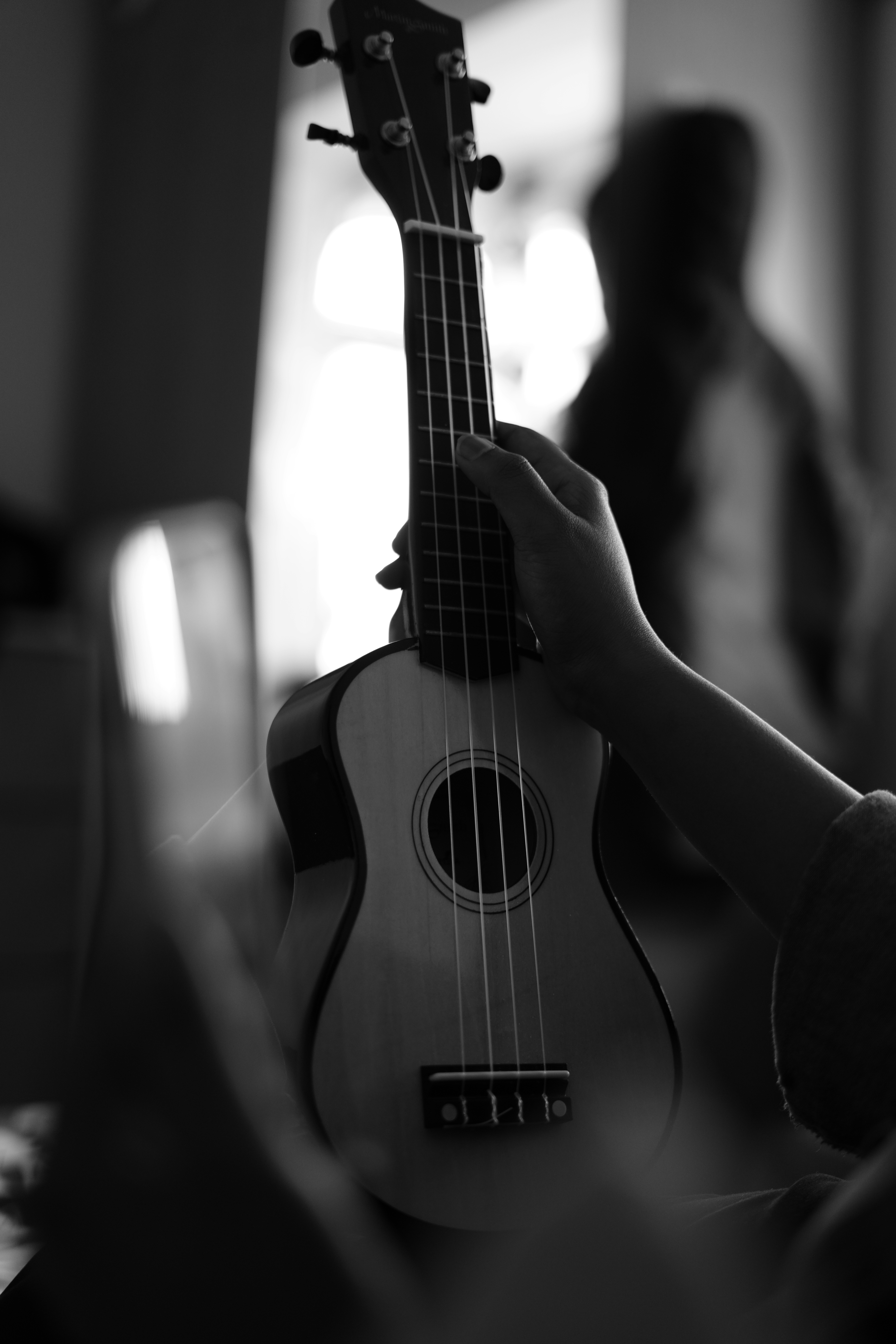 A black and white photo of a person holding a ukulele photo – Free ...