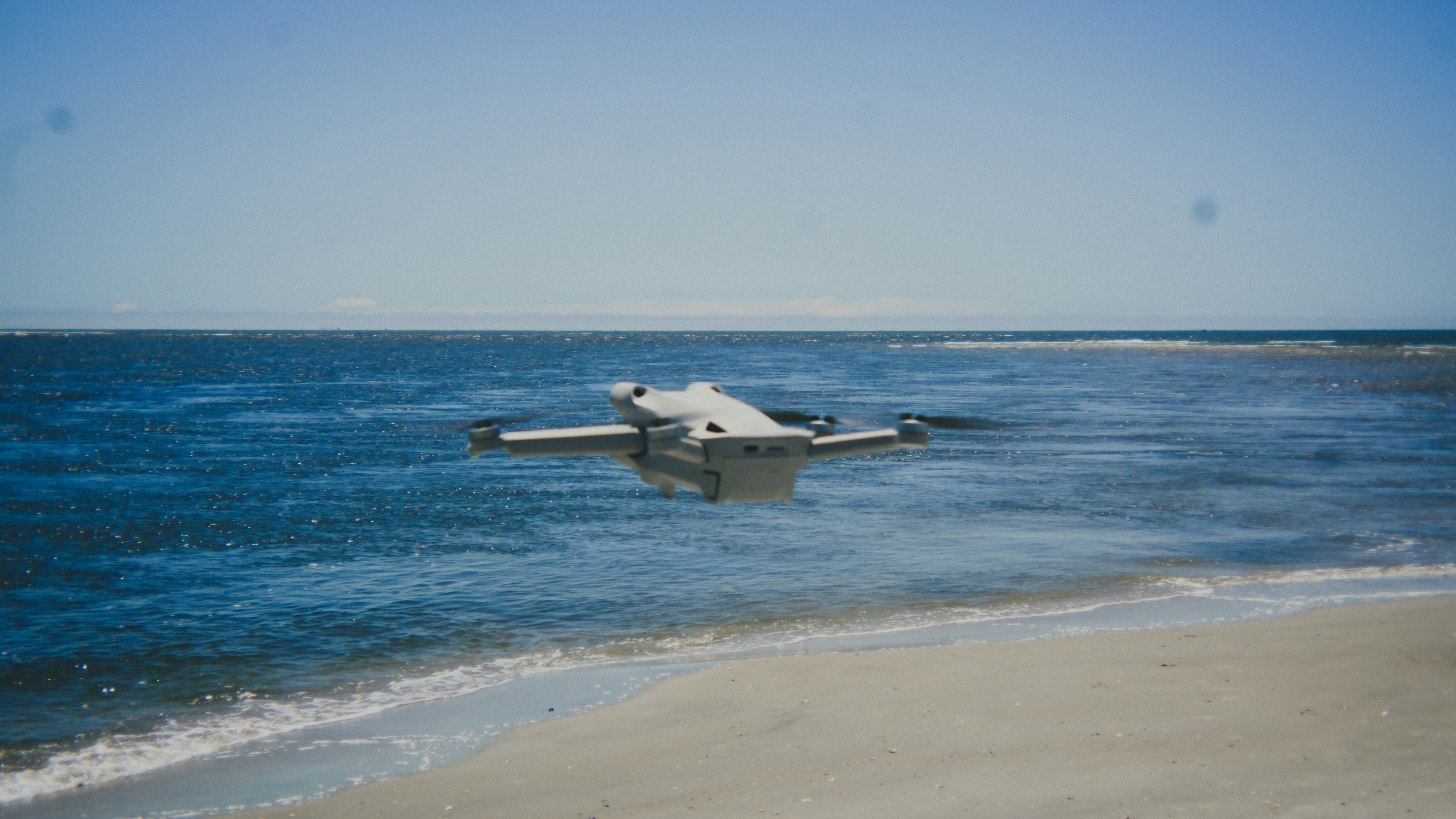 A small plane flying over a beach next to the ocean photo – Free Beach ...