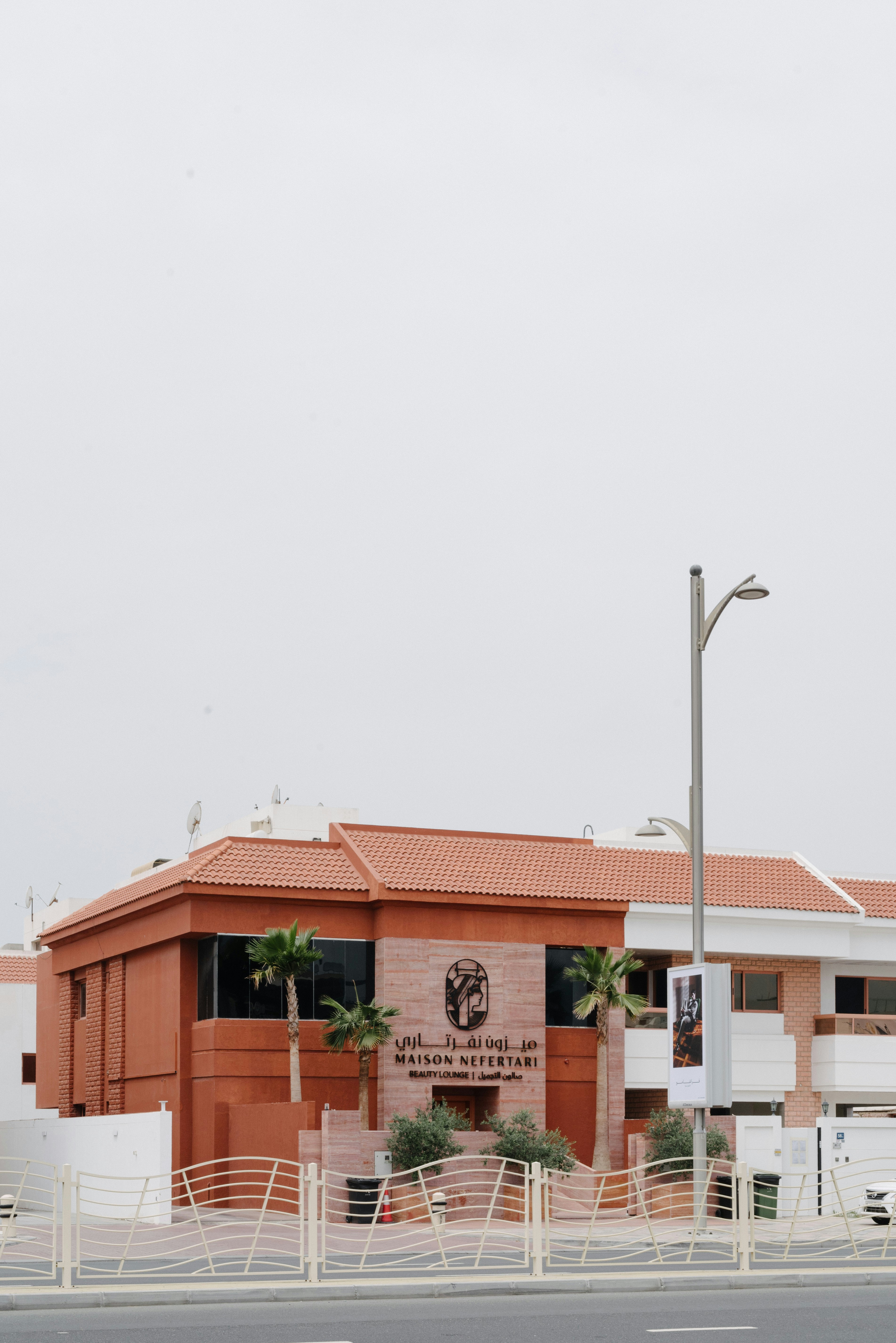 A red brick building with a white fence around it photo – Free La mer ...