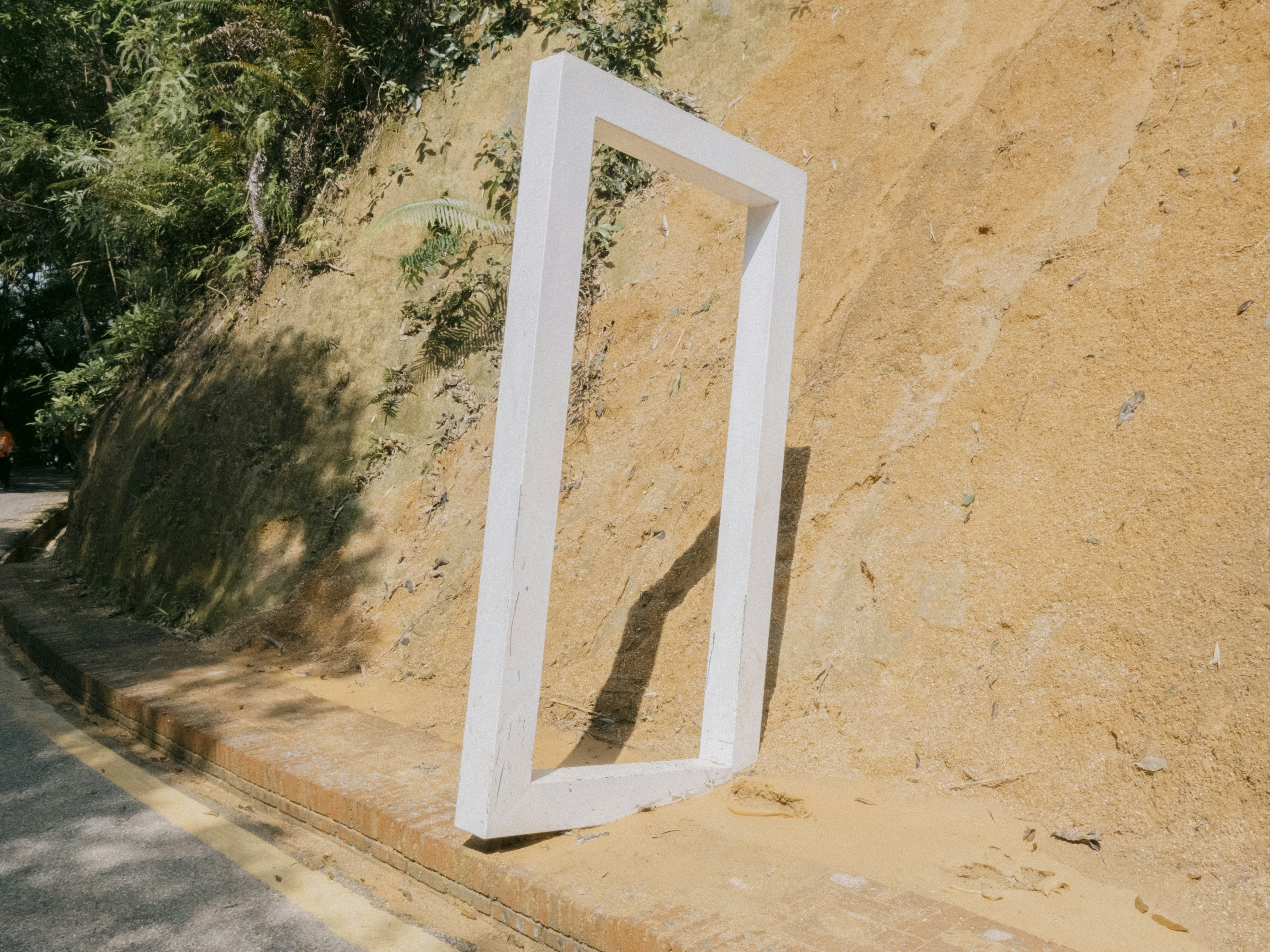 Leaning Frame of Light: A Quiet Portal Along a Sunlit Cliff Path