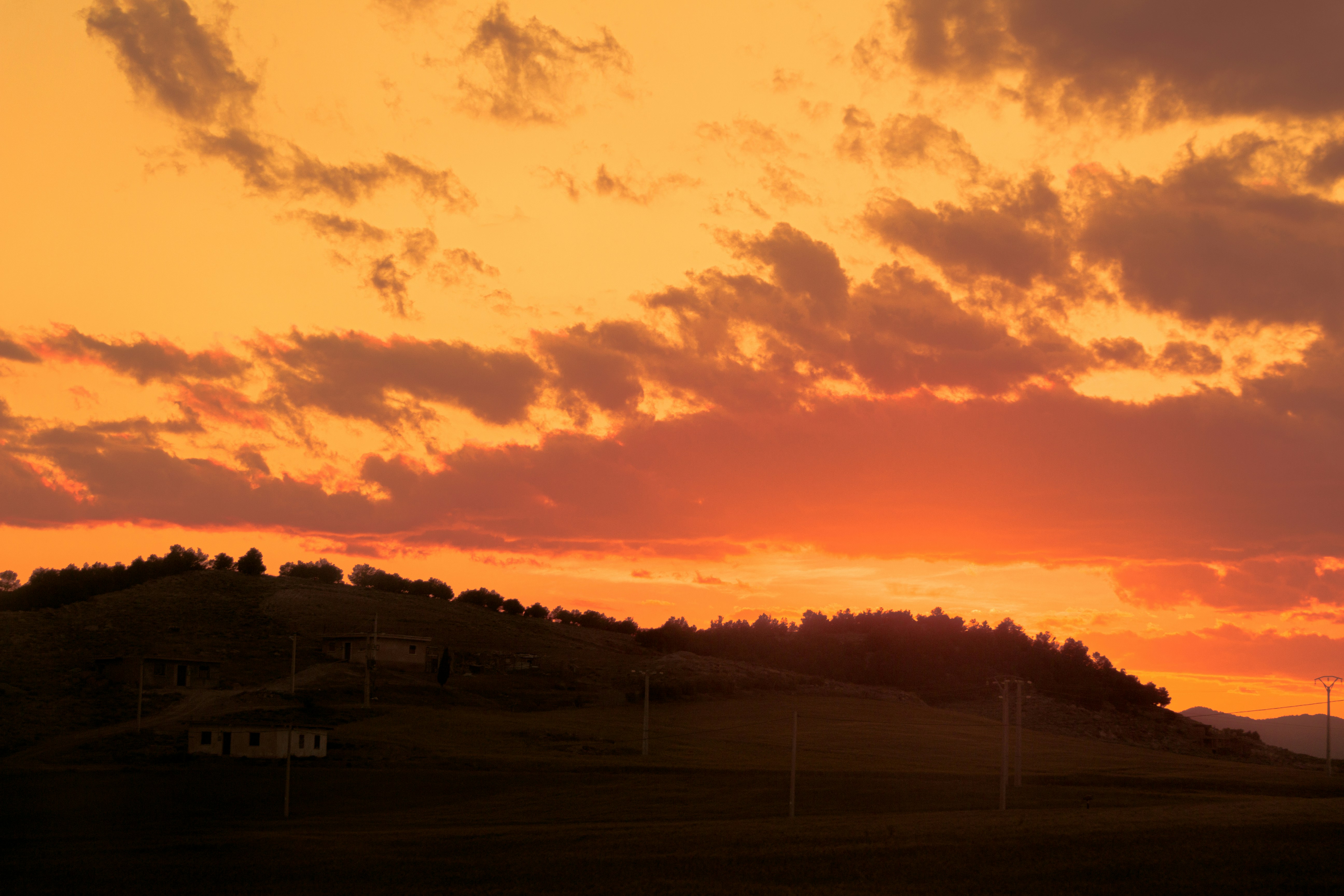 The sun is setting over a hill with houses on it photo – Free Nature ...