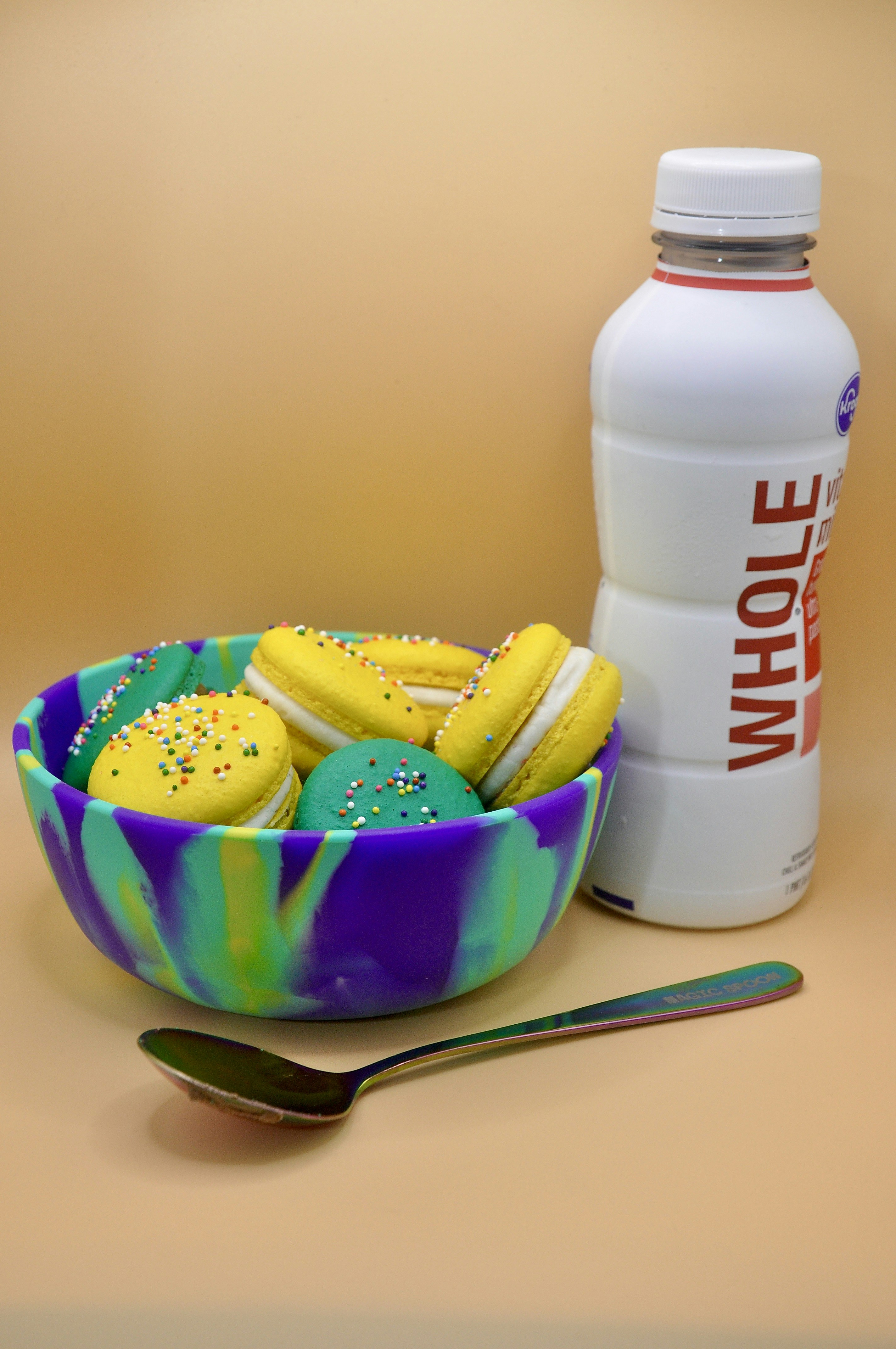 Sweet Center: A Vibrant Bowl of Colorful Macarons and a White Wellness Bottle