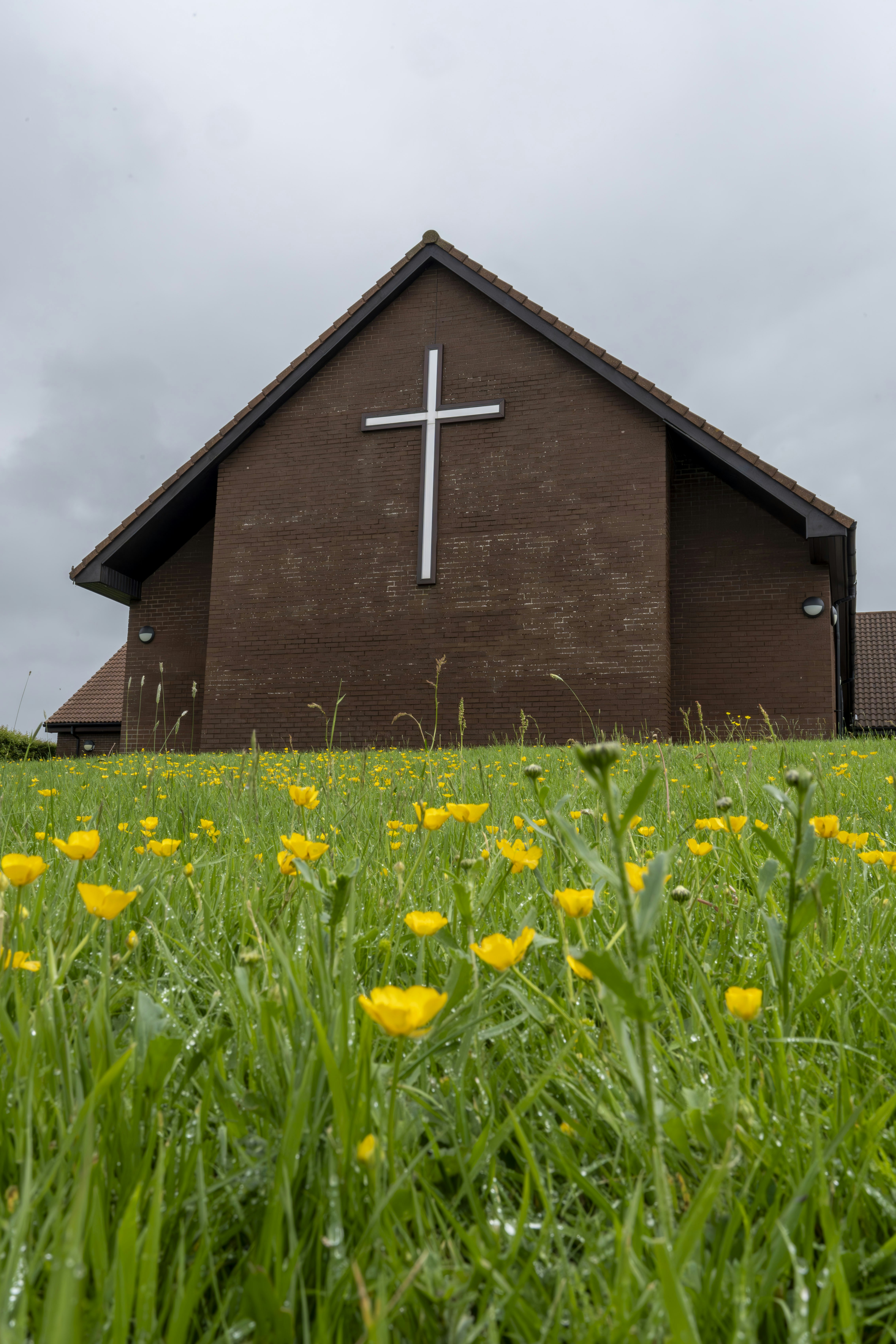 Lawn of gold: a brick chapel under a moody sky