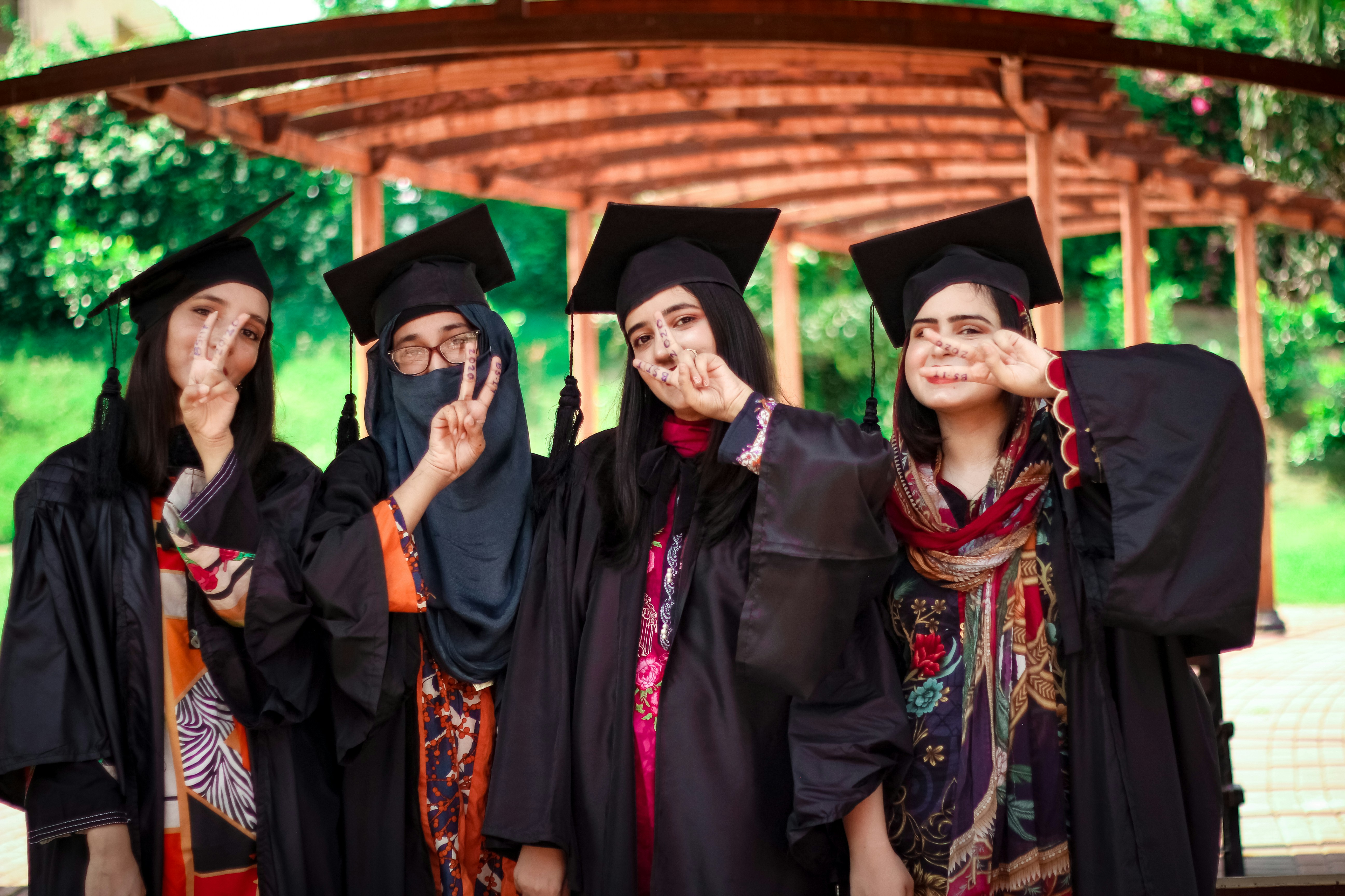A group of people in graduation gowns posing for a picture photo – Free ...