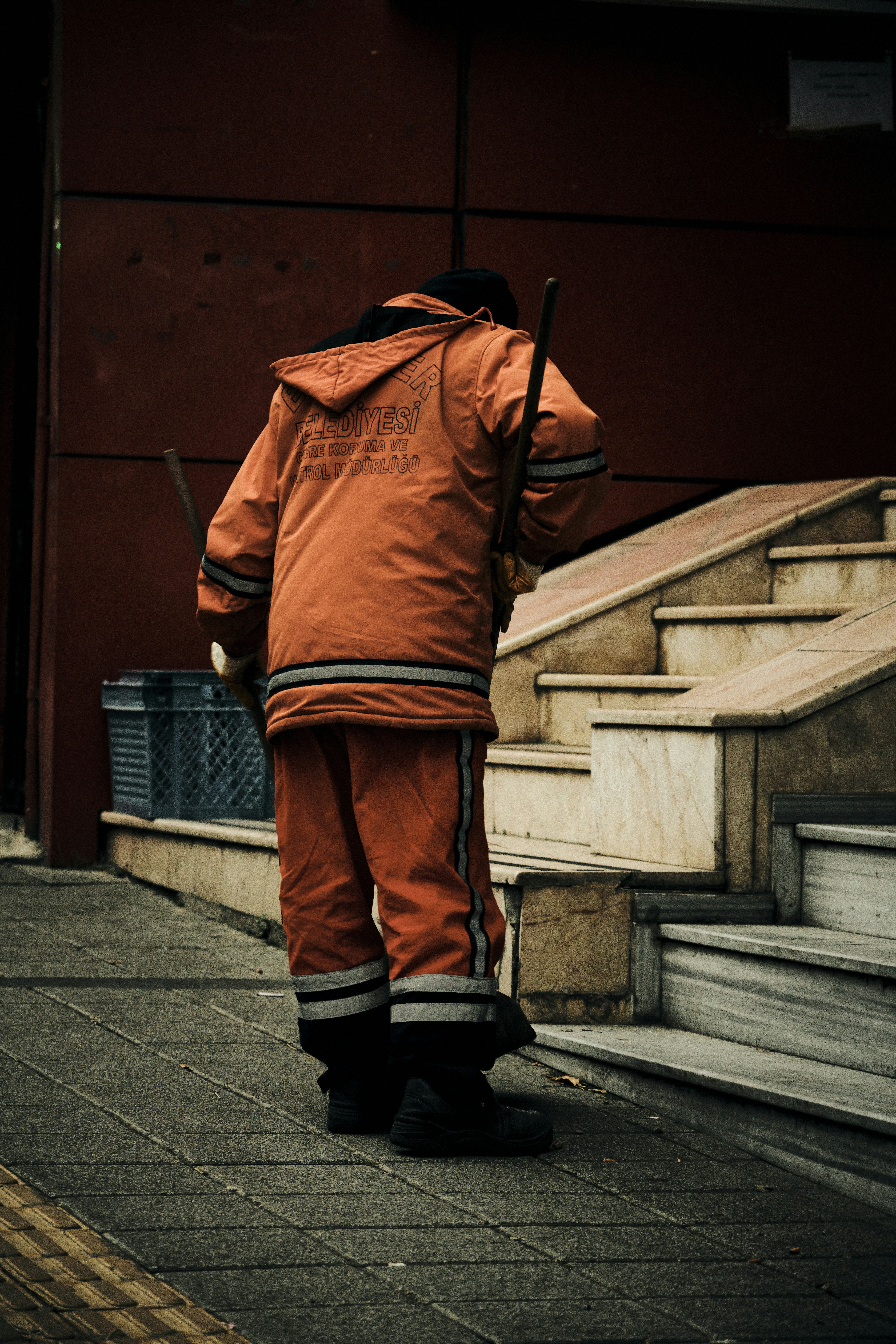 Una persona con un traje de bombero naranja caminando por una acera ...