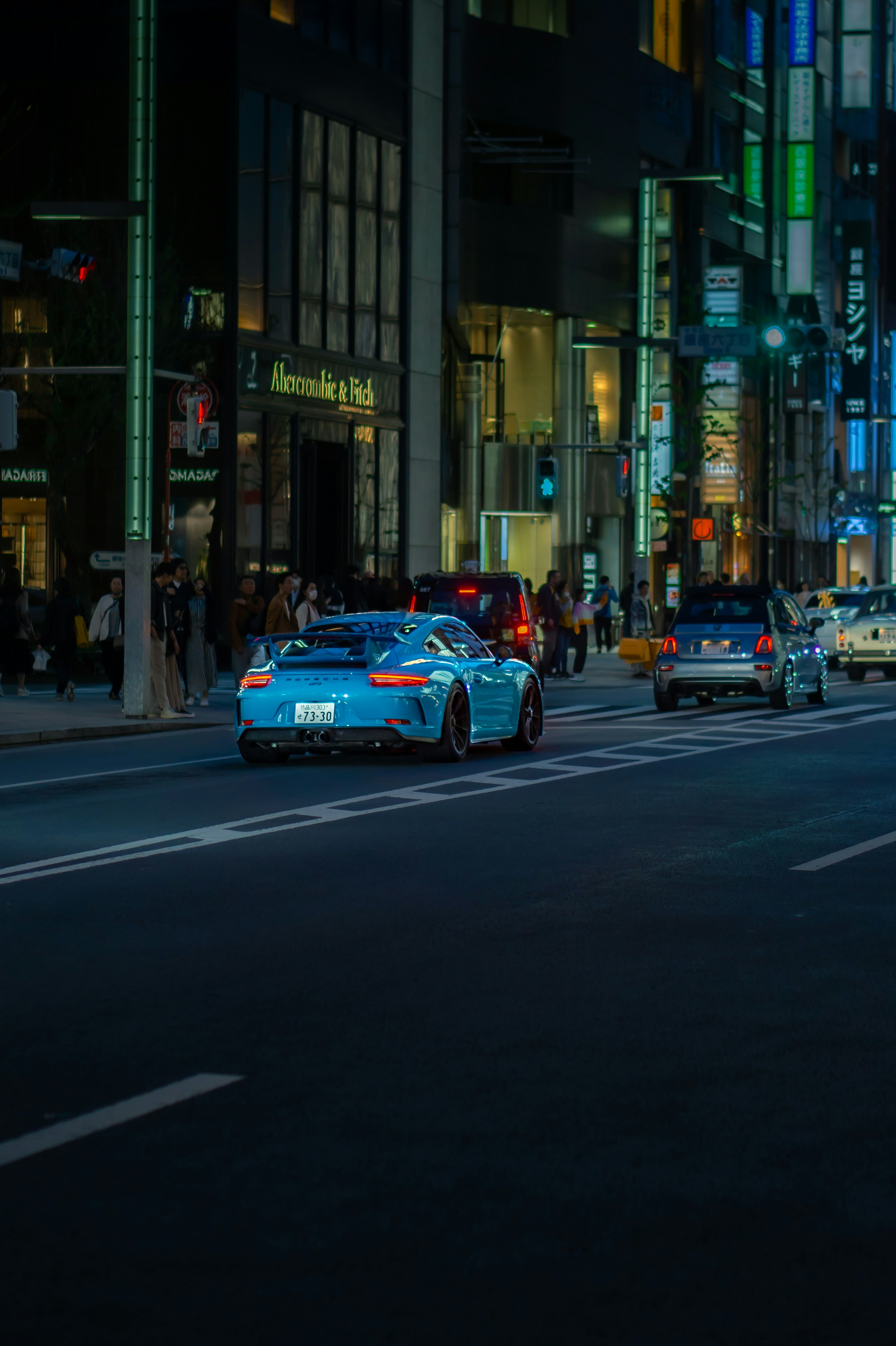 Azure Neon Rush: A Blue Sports Car Slices Through Night Midtown