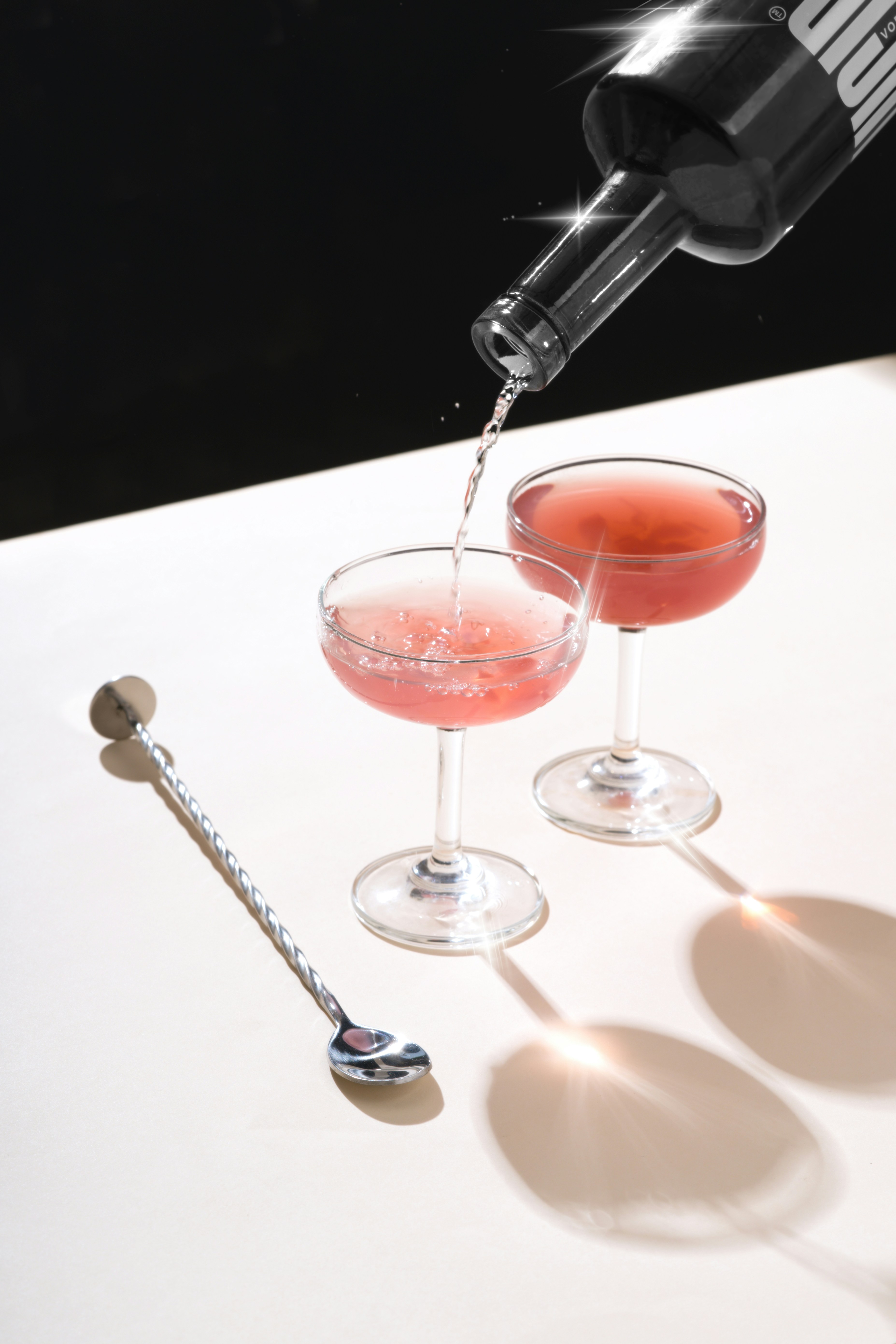 Una botella de alcohol que se vierte en dos vasos foto – Imagen de ...
