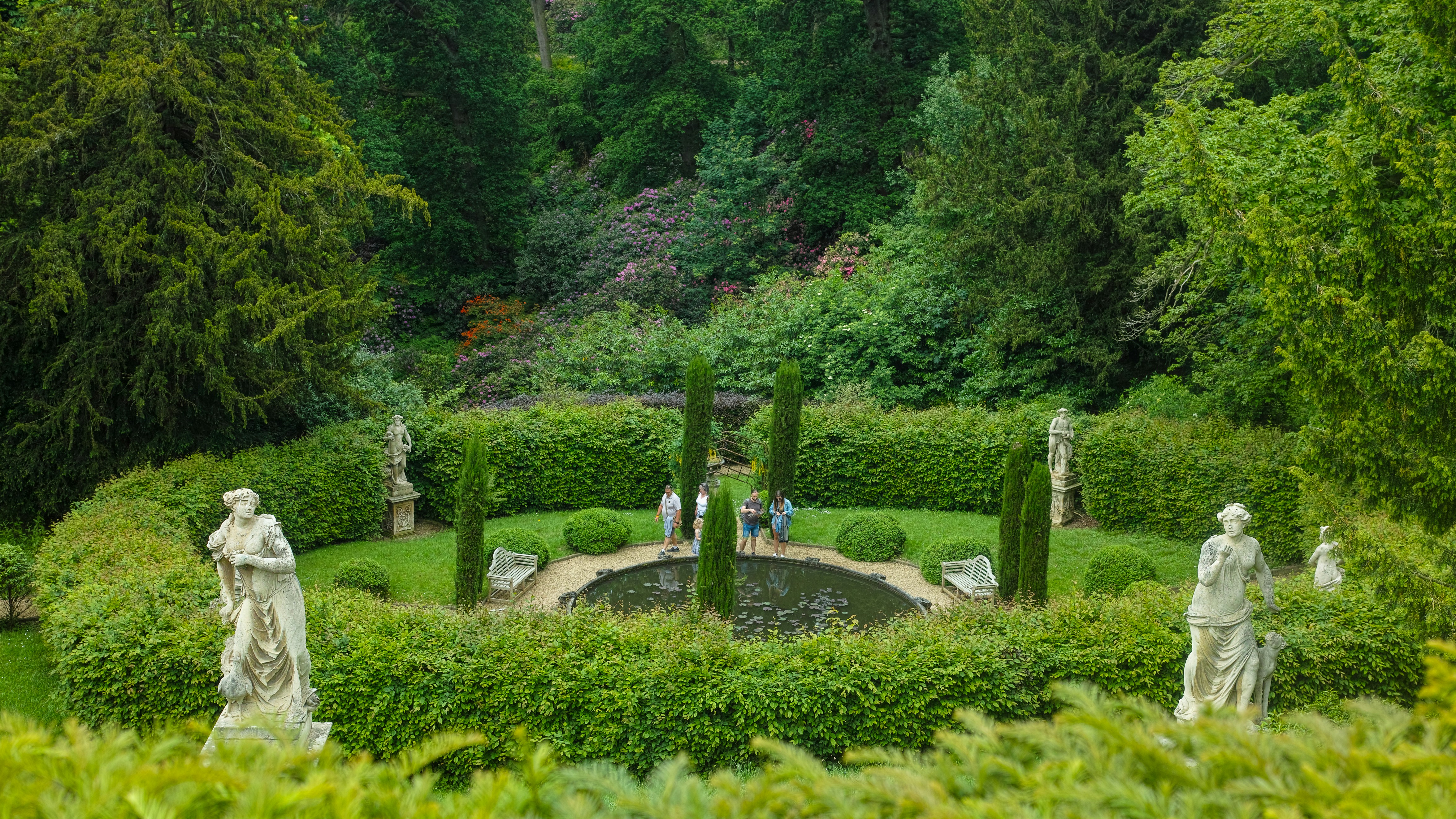 A group of statues in a garden surrounded by trees photo – Free Forest ...