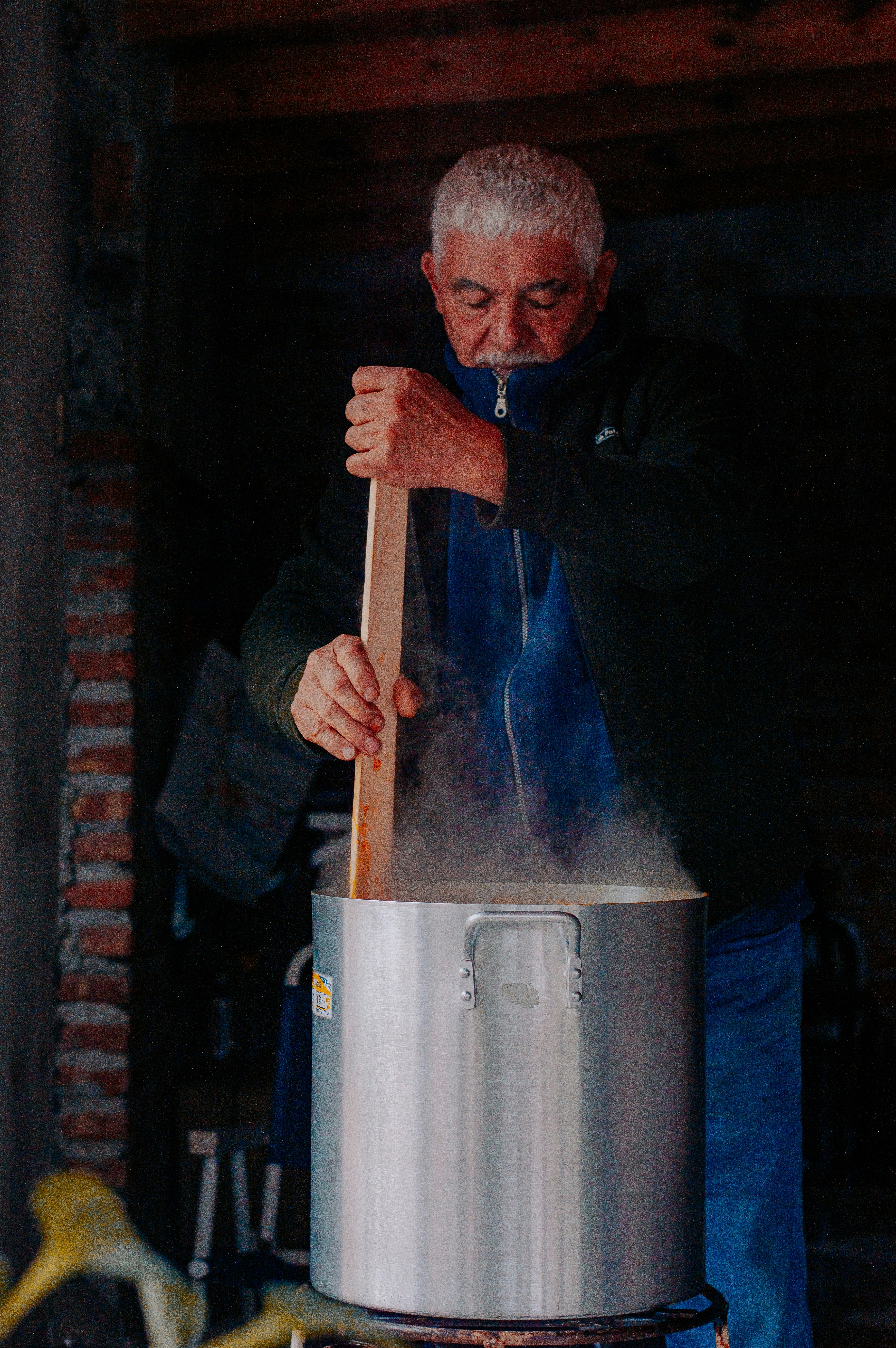 A man stirring a pot with a wooden spoon photo – Free Argentina Image ...