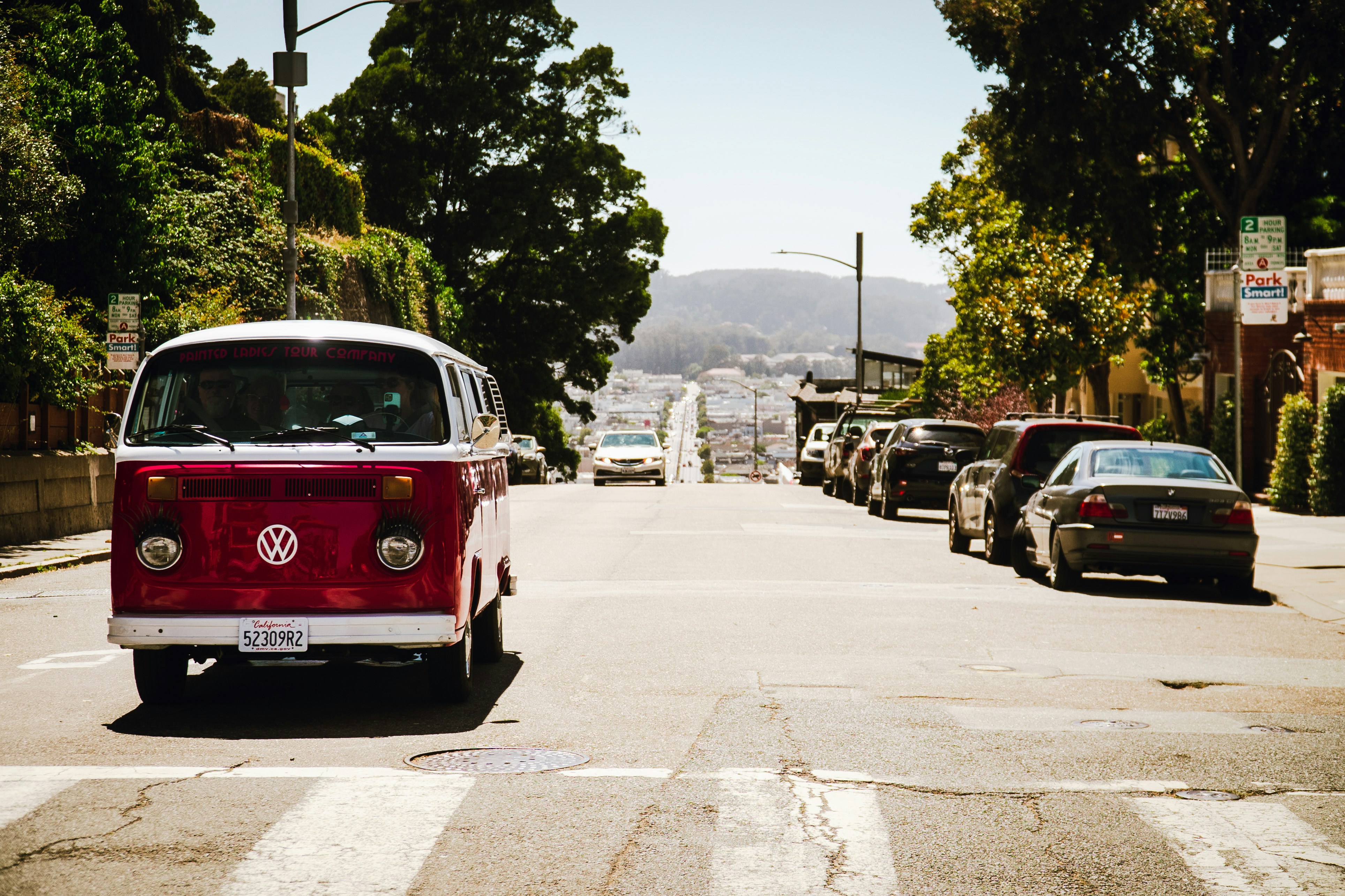 Sun-Drenched Boulevard: A Vintage VW Van Leads a Quiet Urban Street