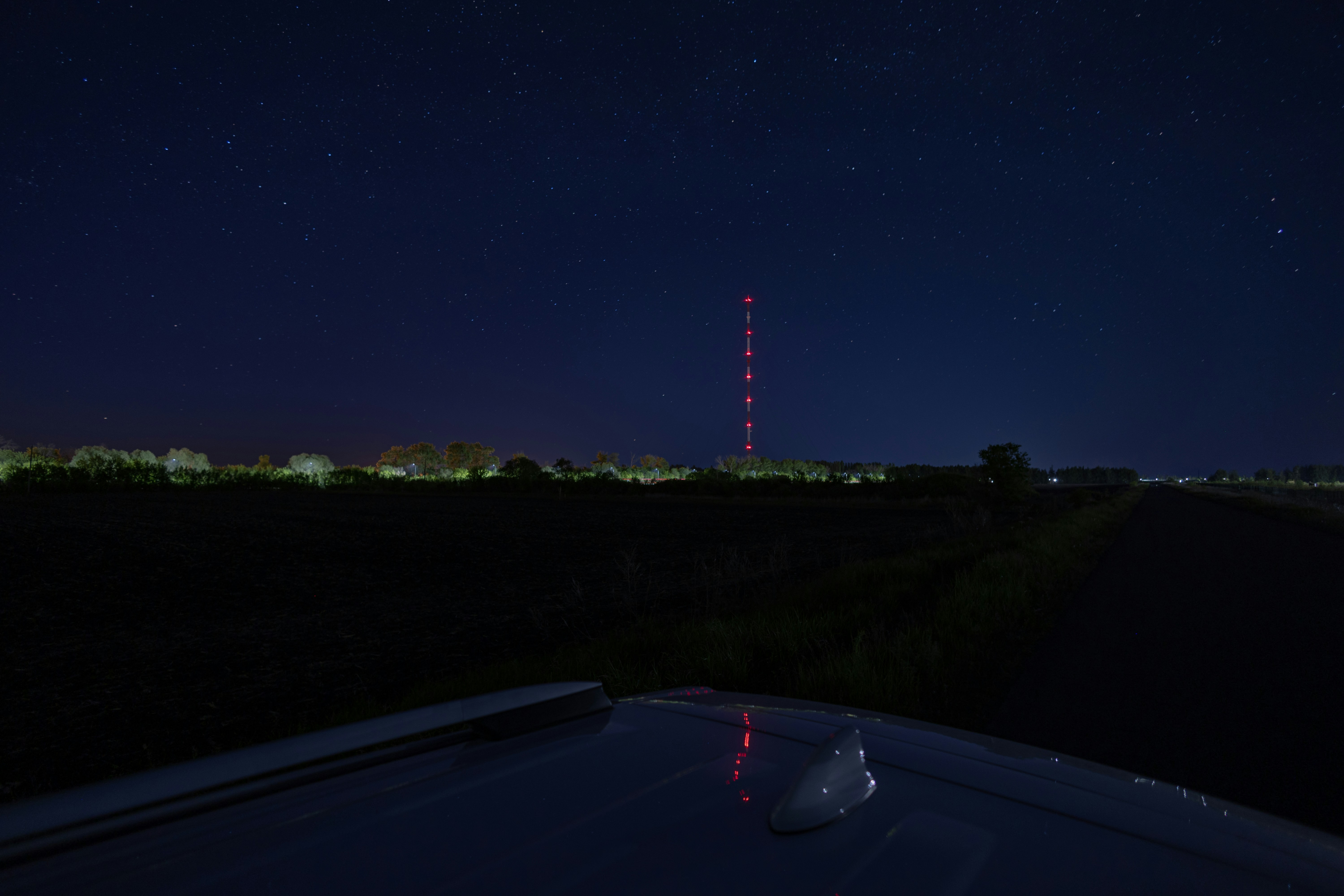 Midnight Beacon Over the Field: Starry Sky and a Blinking Tower