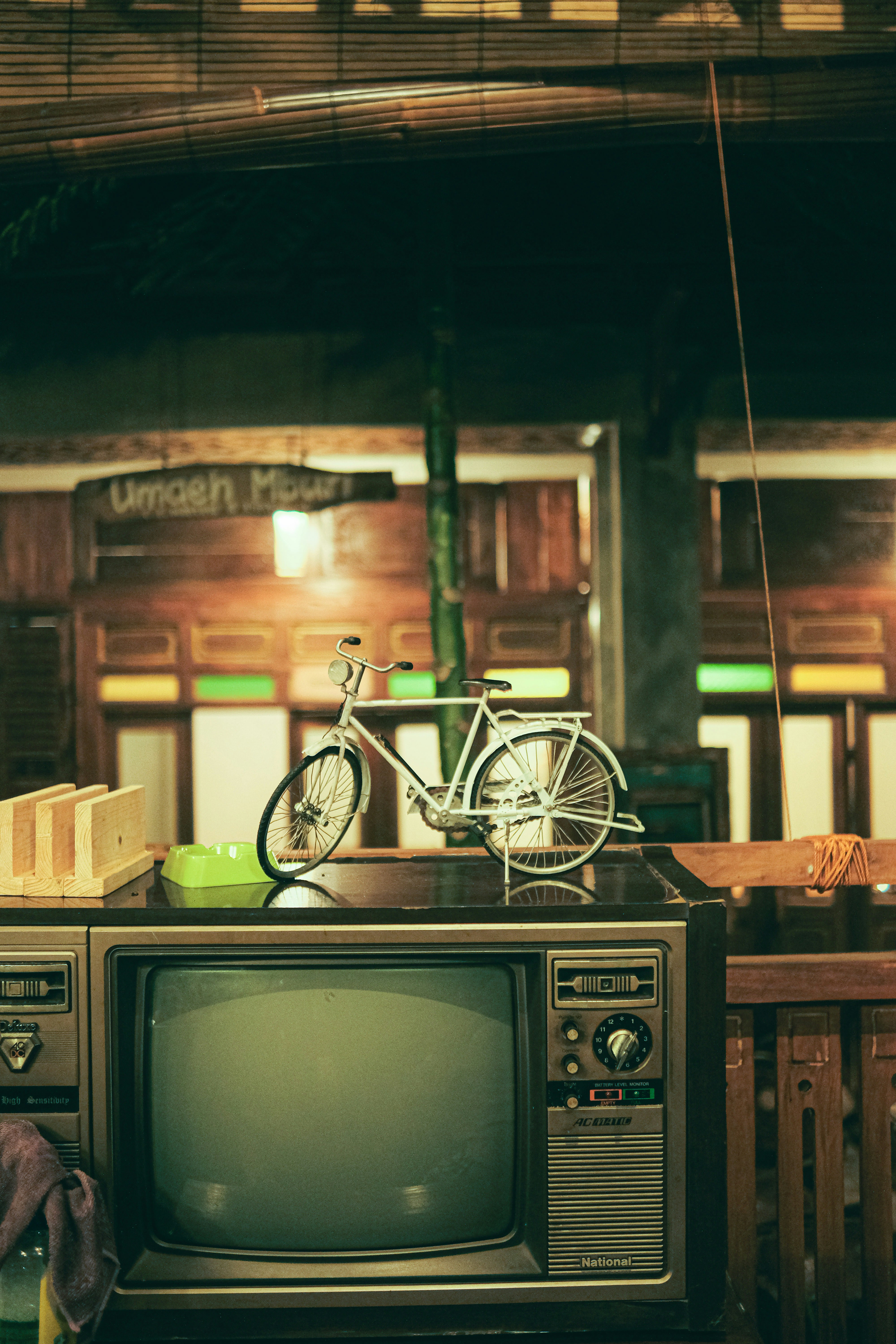 Tiny Bicycle, Big Quiet: A White Pedal Toy Perched on a Retro TV