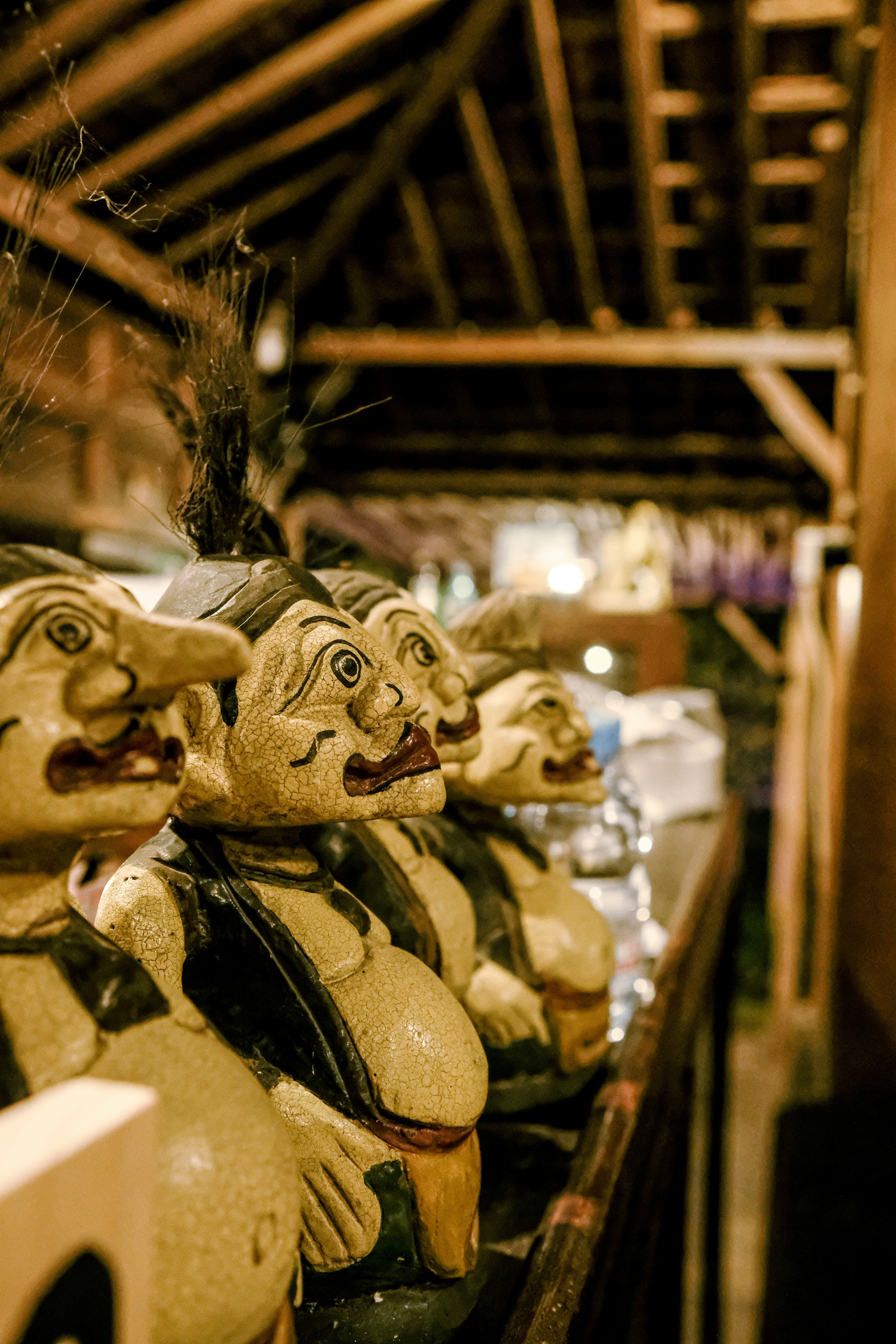A row of wooden statues with faces on them photo – Free Purwokerto ...