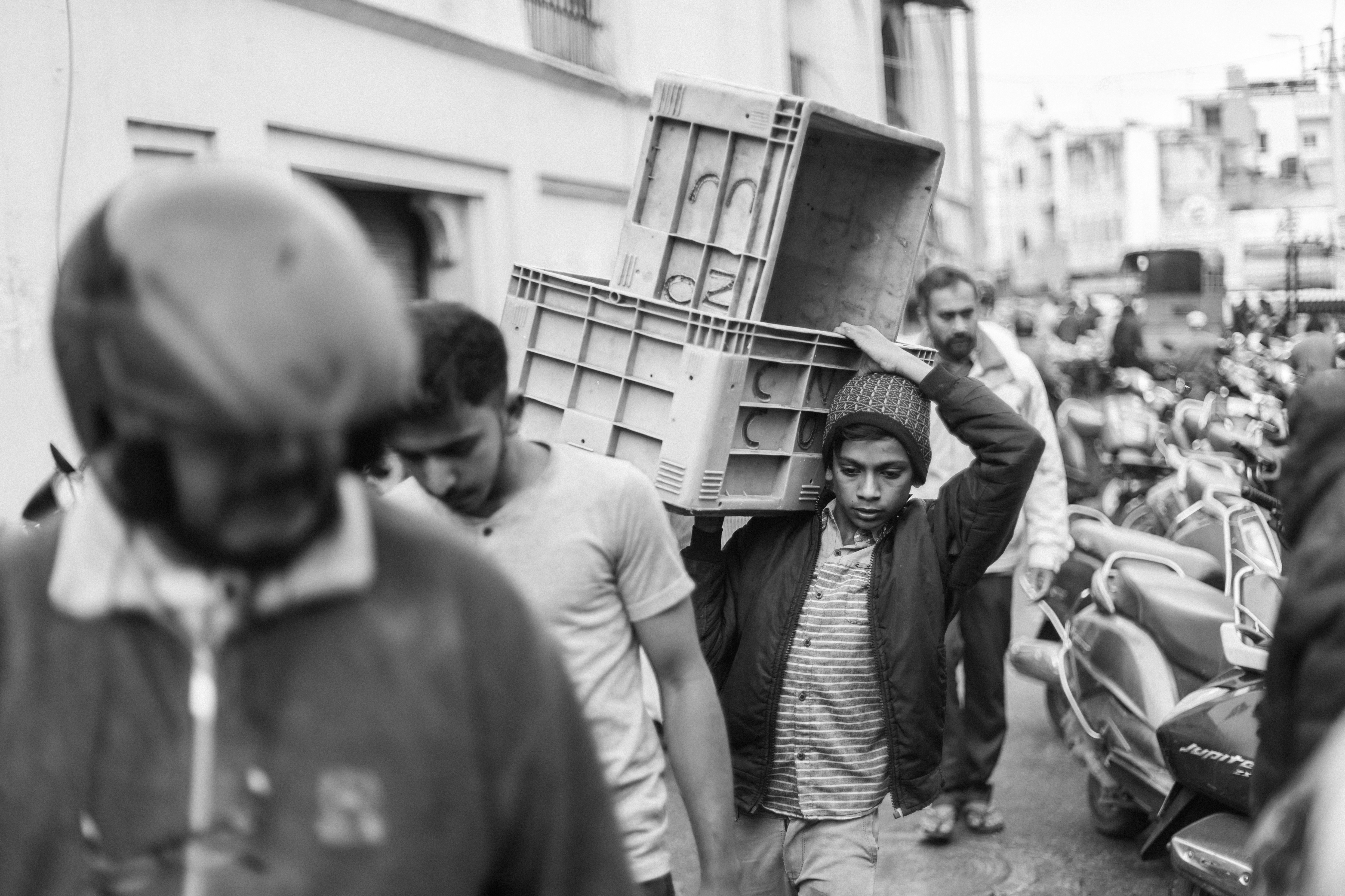 Crate-Bearing Trek Through a Crowded Market Street