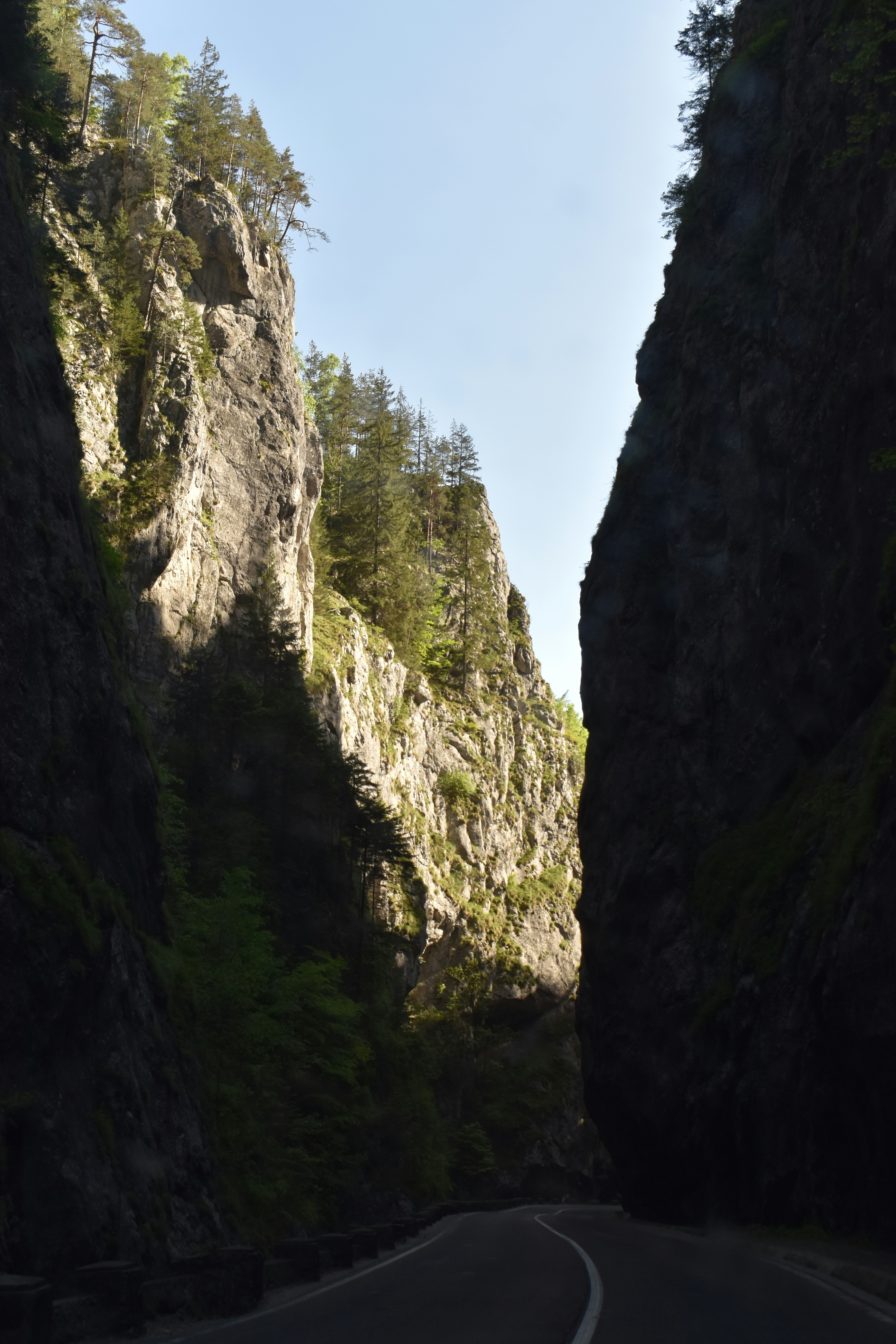 A car driving down a road between two mountains photo – Free România ...