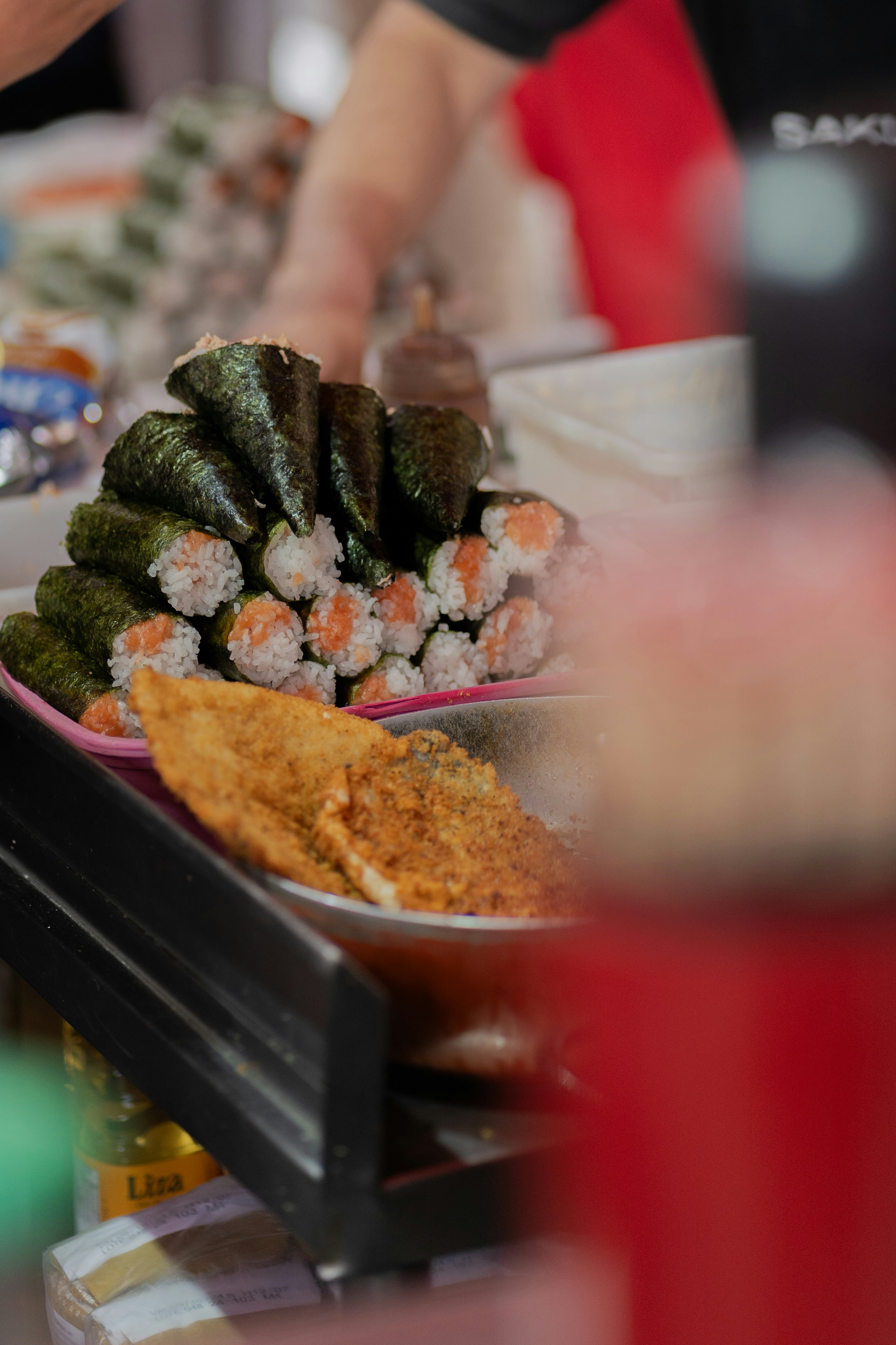 Nori-Wrapped Sushi Towers on a Bustling Market Counter