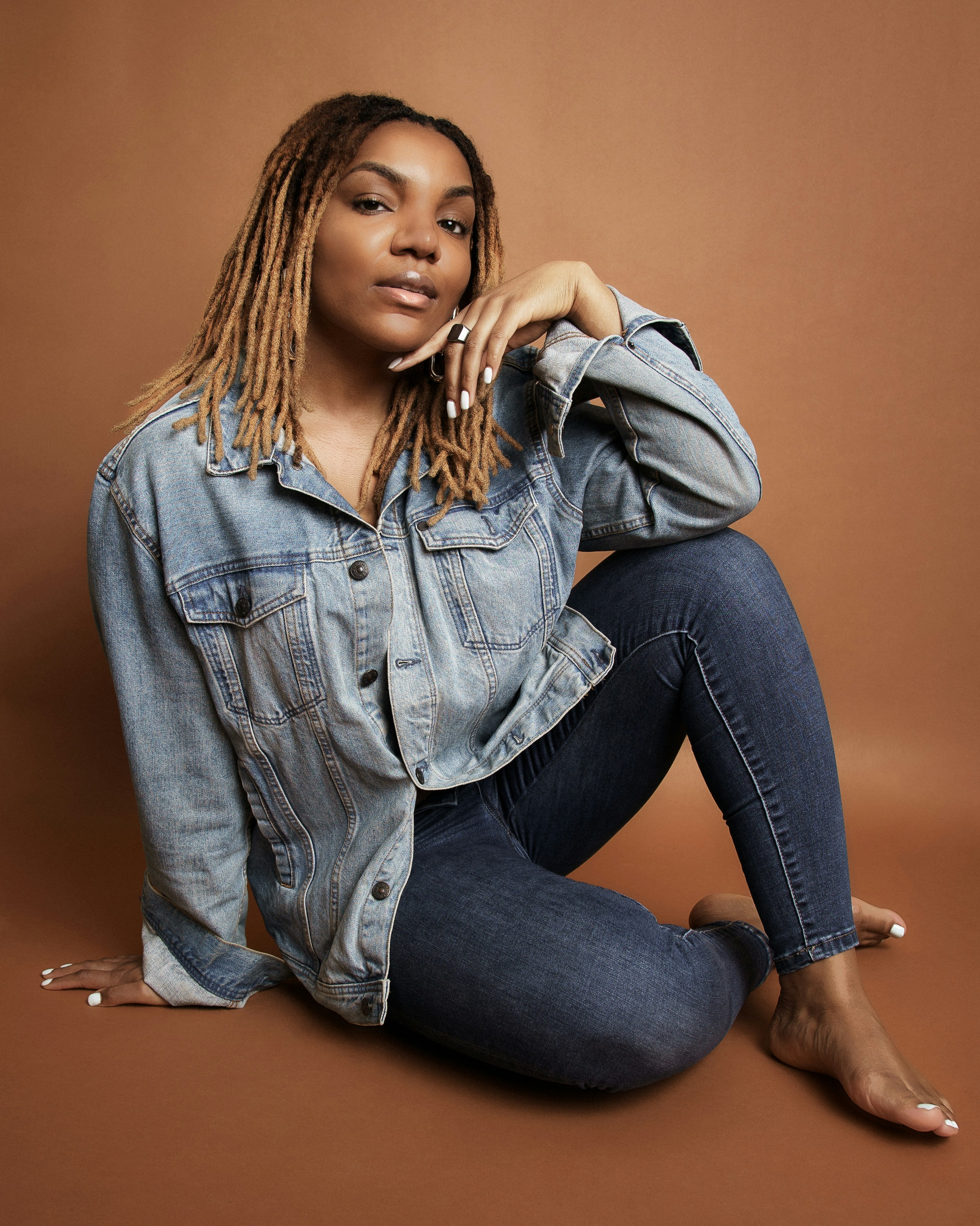 A woman with dreadlocks sitting on the ground photo – Free Chicago ...
