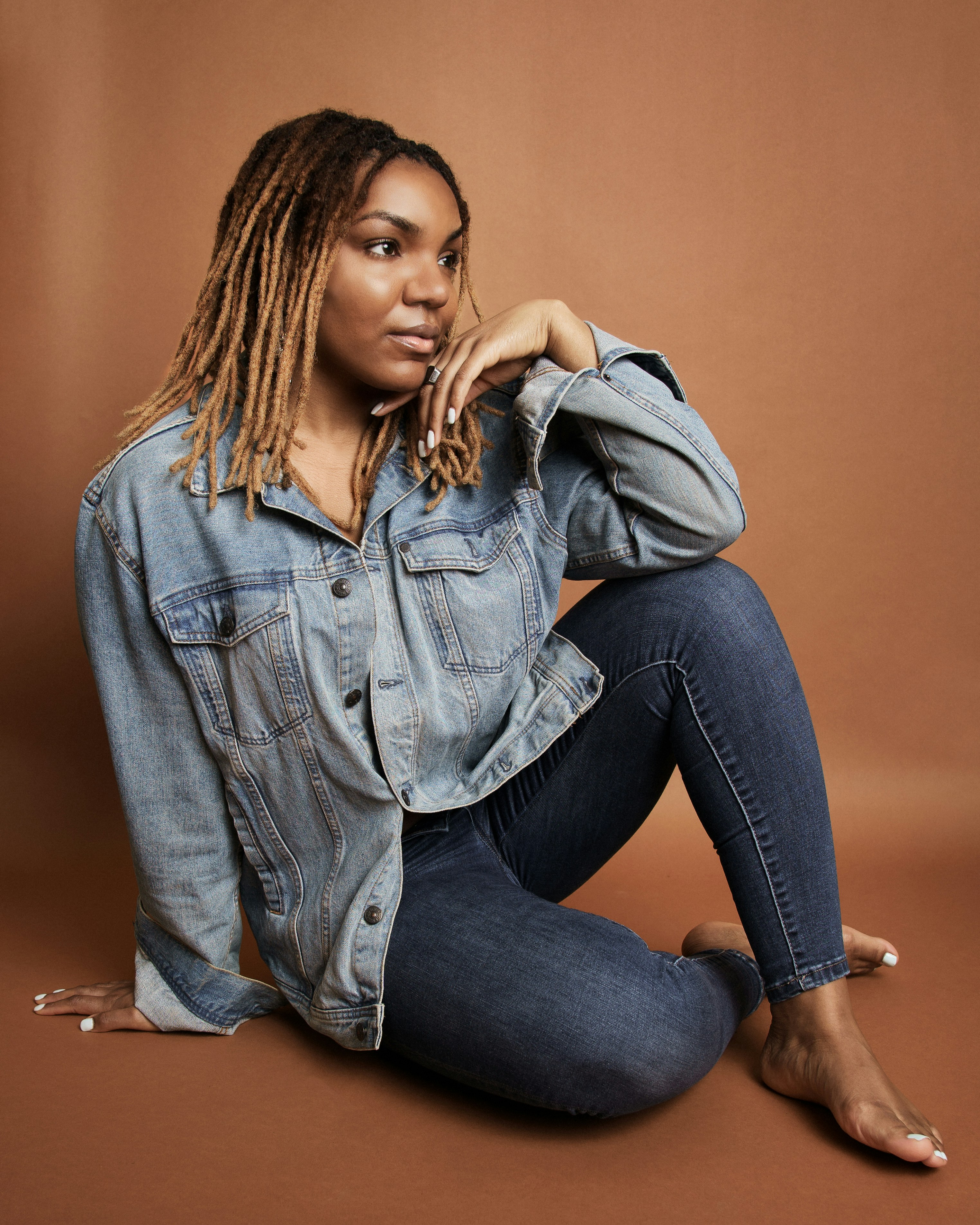 A woman with dreadlocks sitting on the ground photo – Free Chicago ...