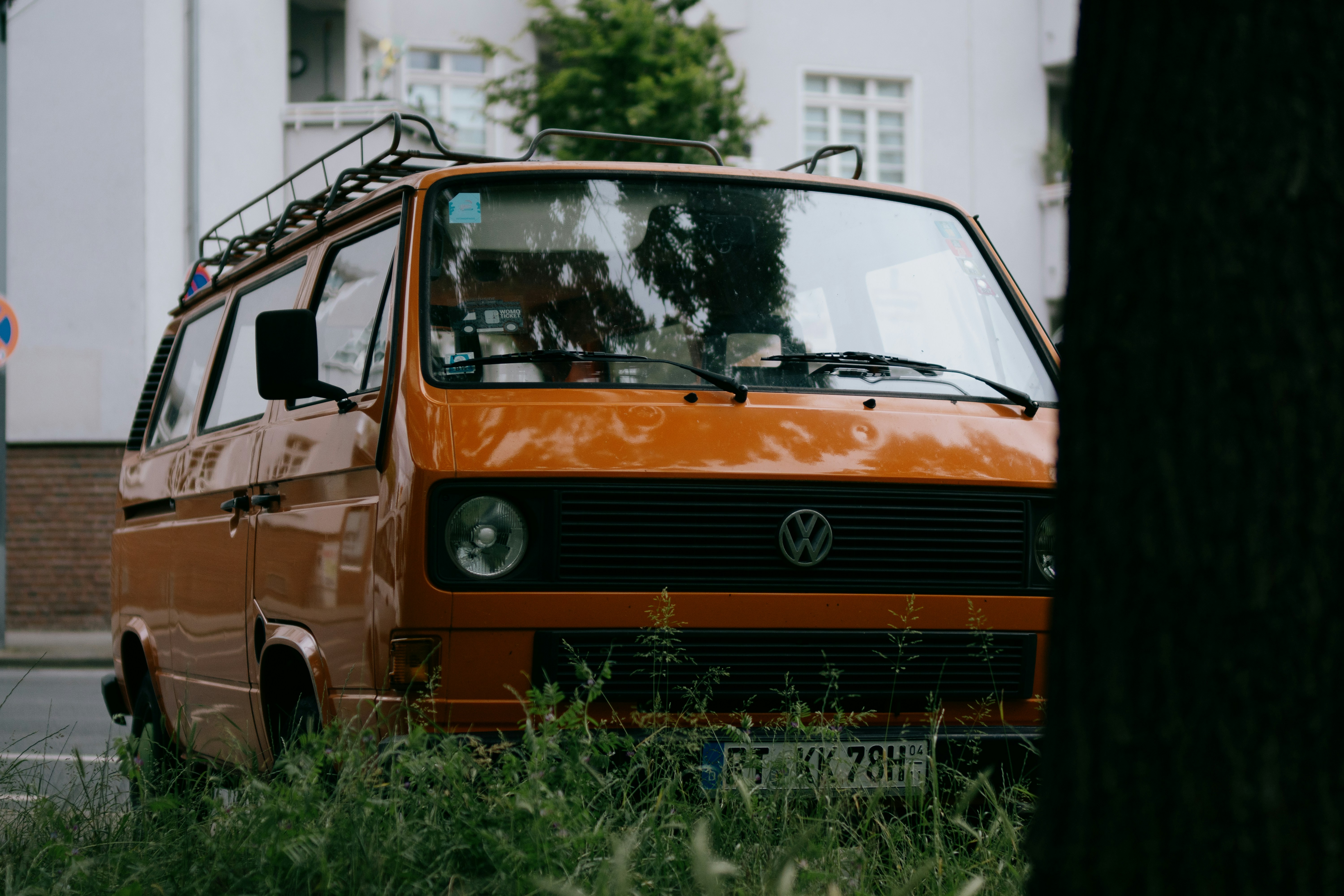 An orange van parked on the side of the road photo – Free Van Image on ...