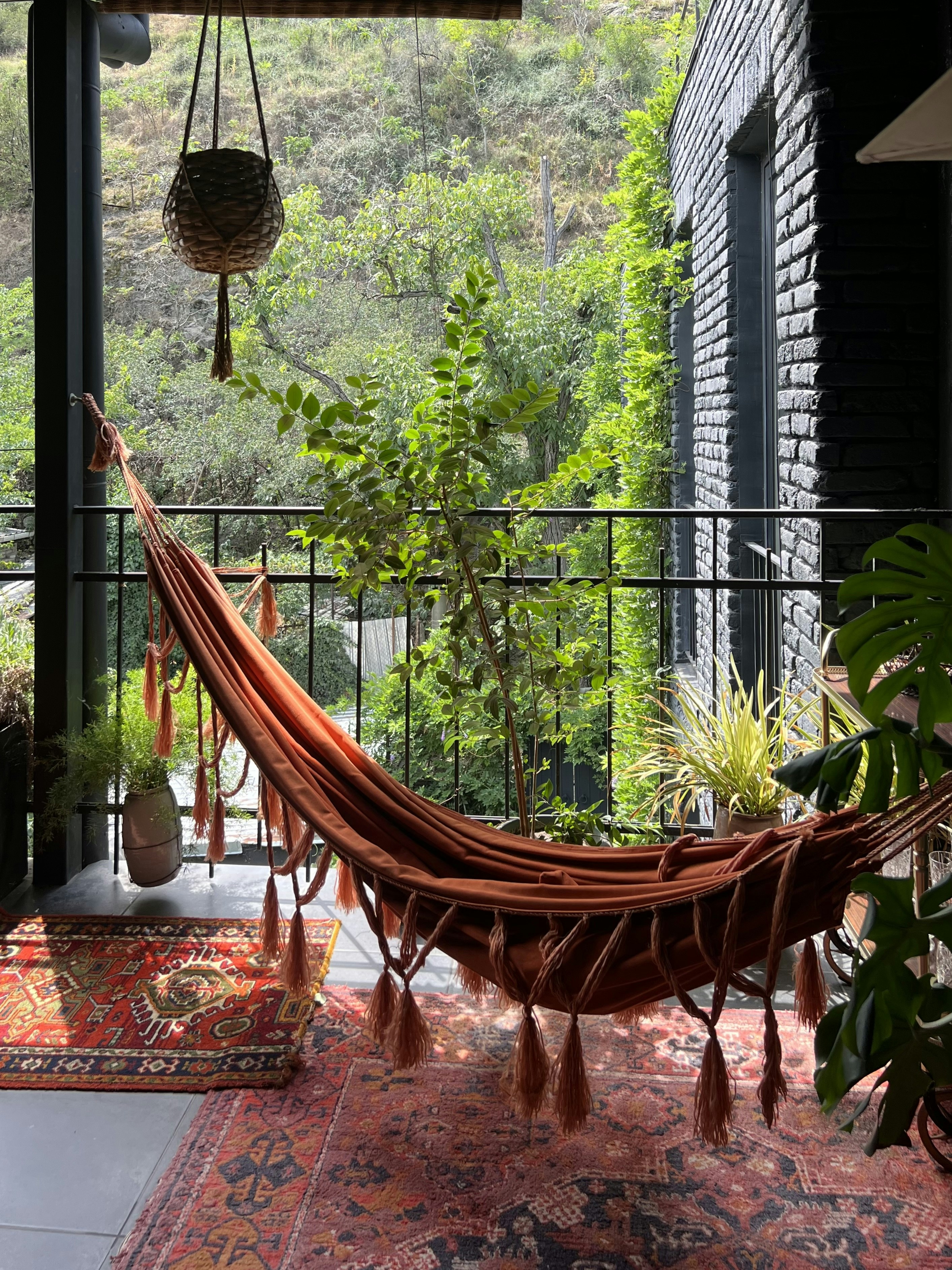 Orange Hammock Draped Across a Green Balcony Oasis