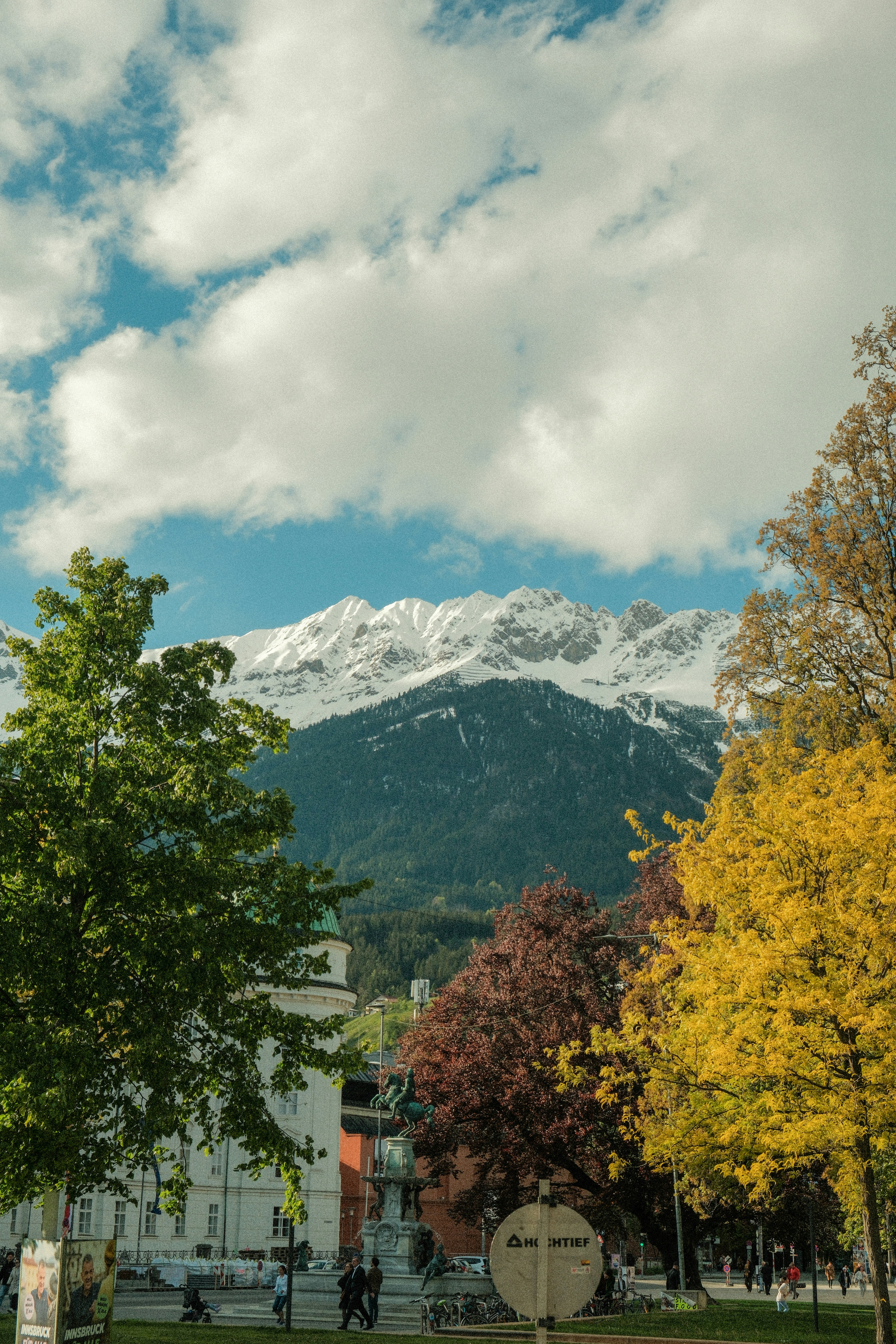 Alpine Square in Autumn Light: Snowy Peaks Framing a Town Statue