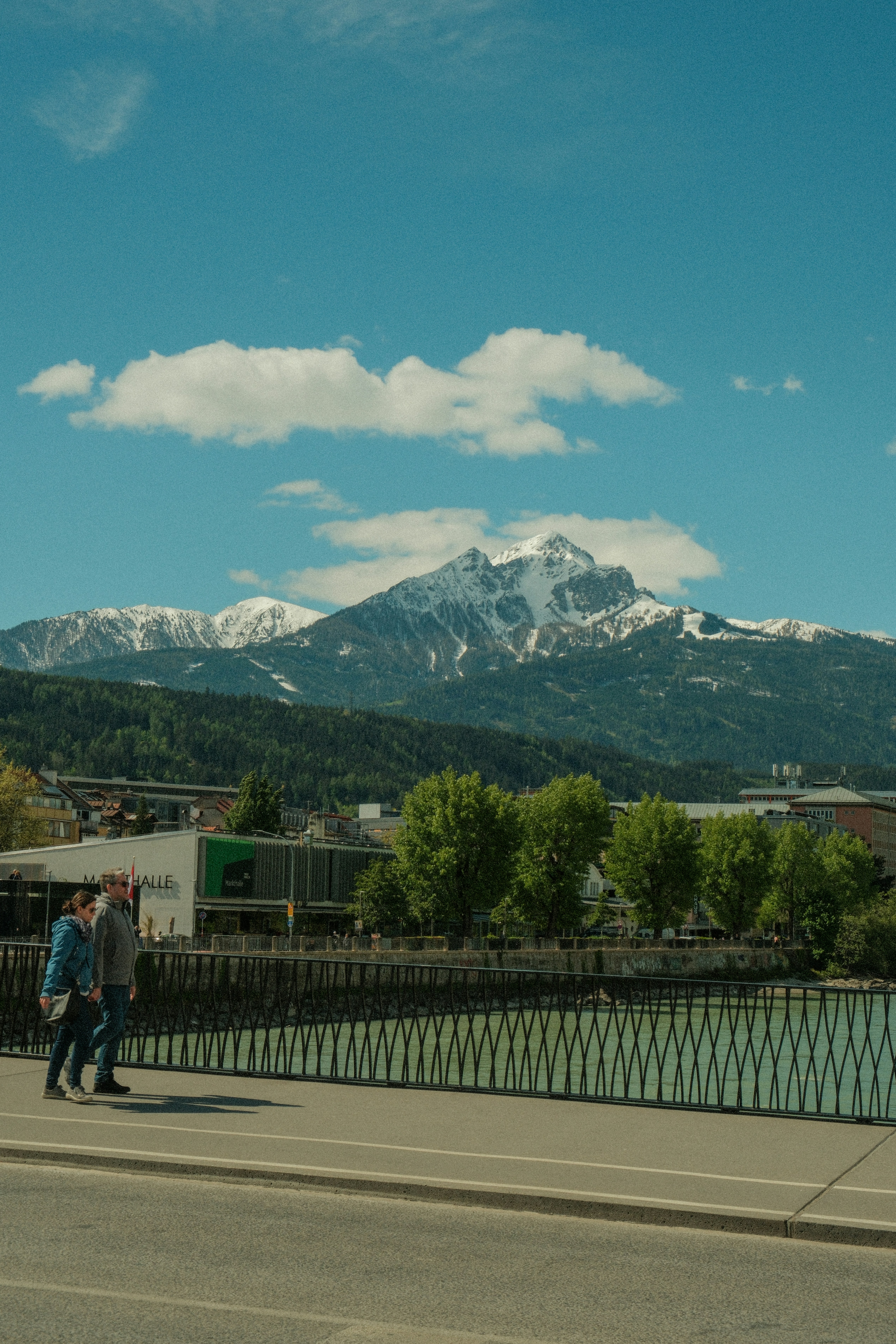 Snow-capped Peaks Over a Quiet Riverside Walkway