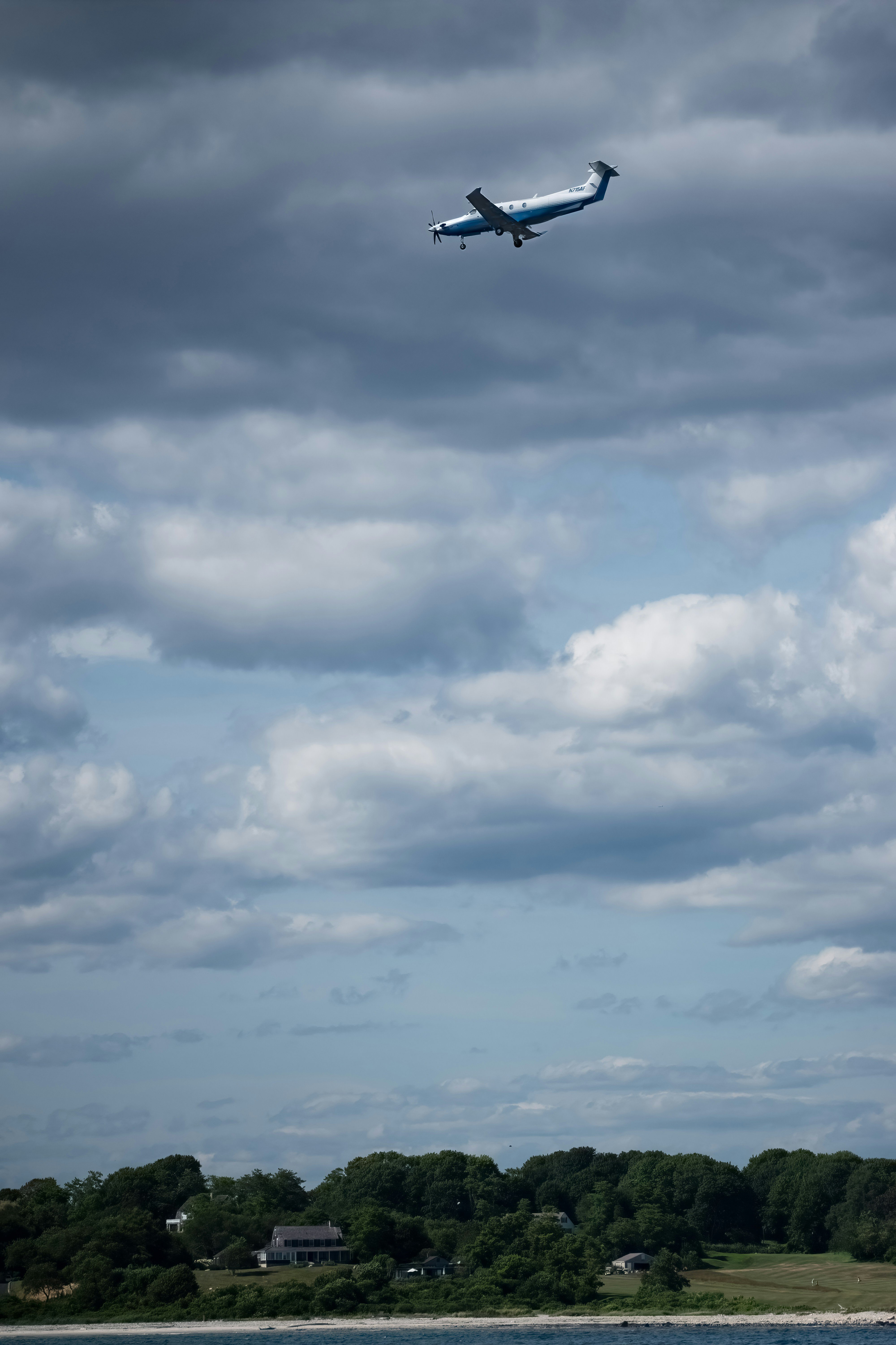 A plane flying over a body of water photo – Free Grey Image on Unsplash