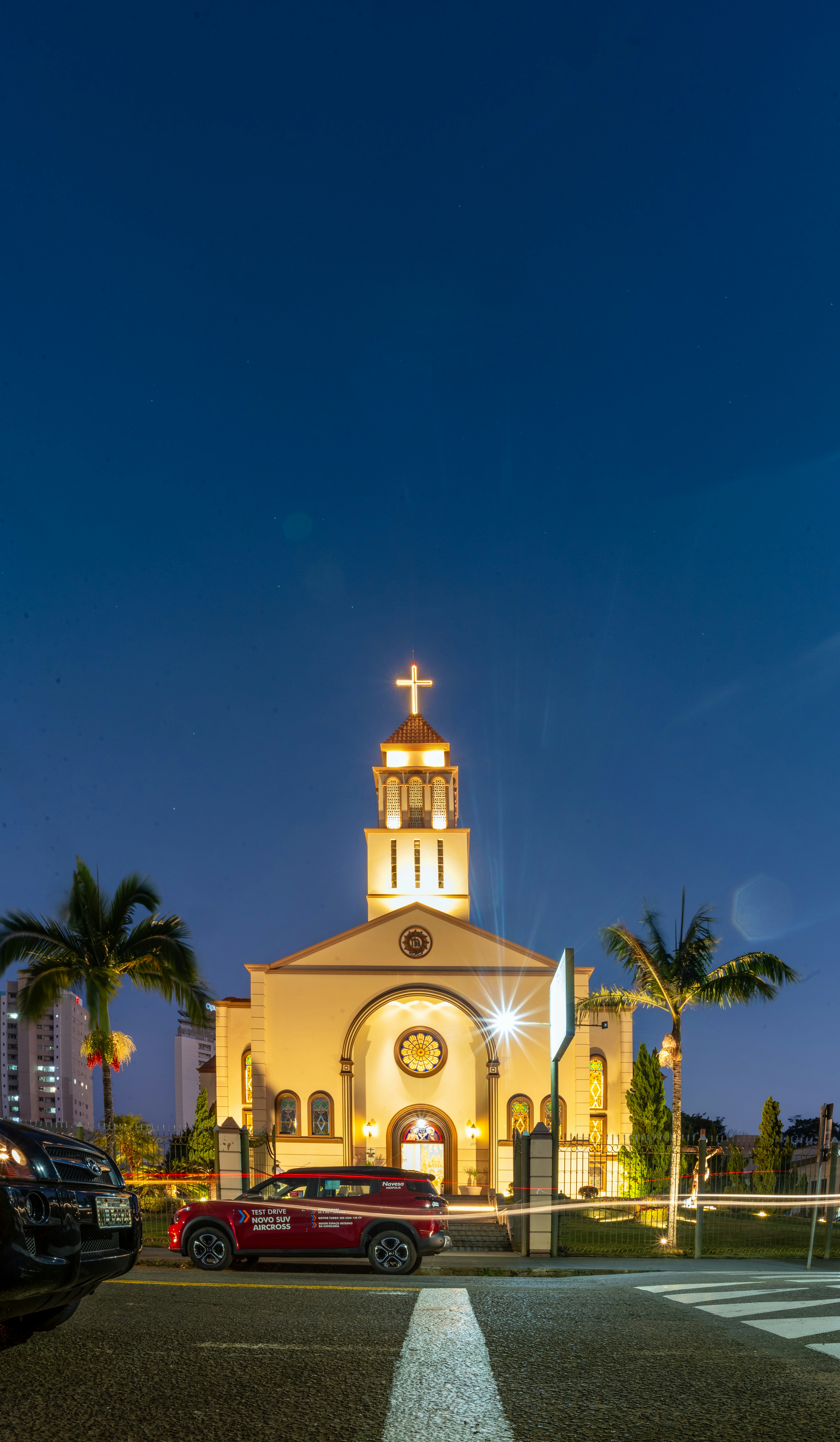 A church lit up at night with cars parked in front of it photo – Free ...