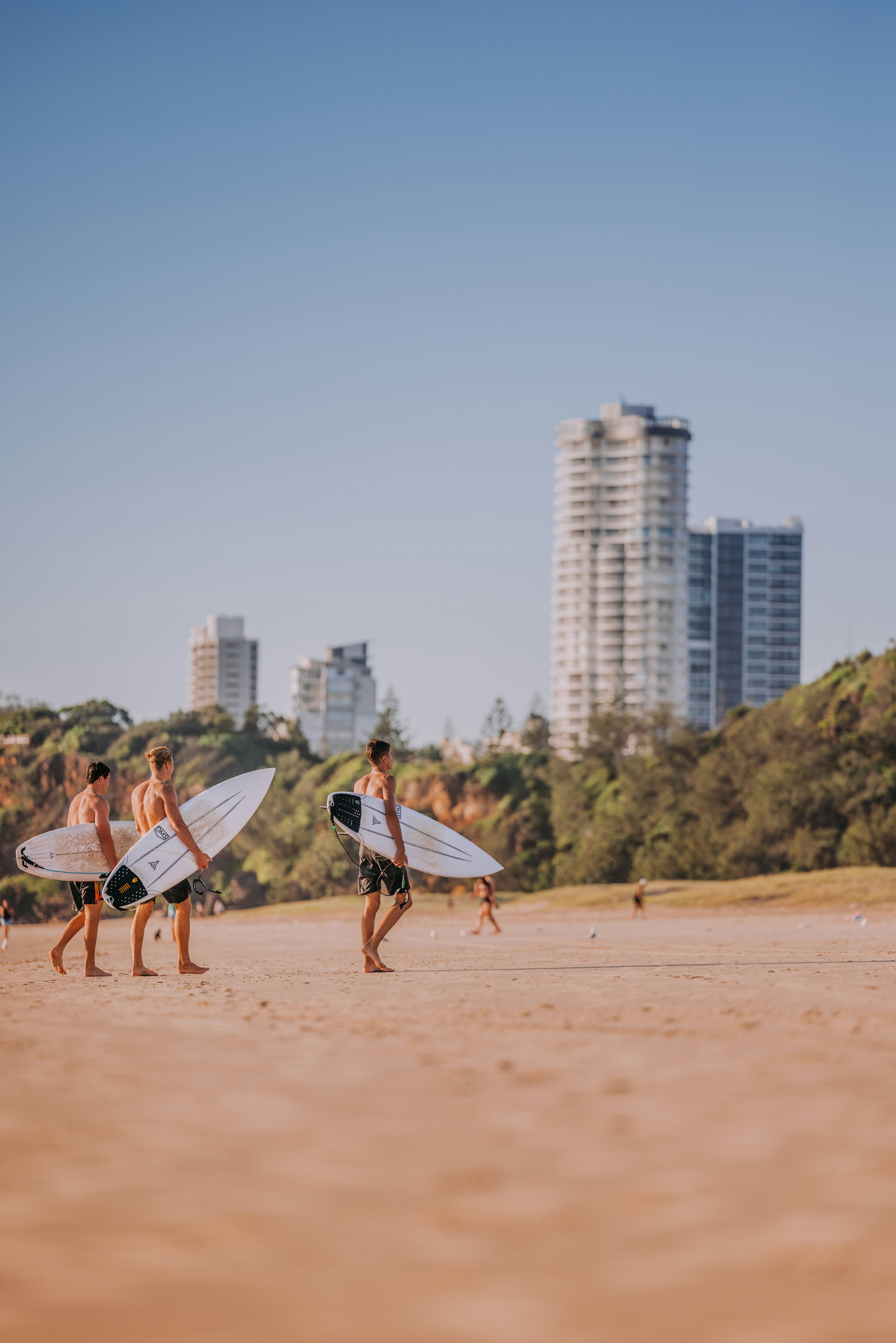 Sunlit Surfers Return: Golden Sand and Skyscrapers