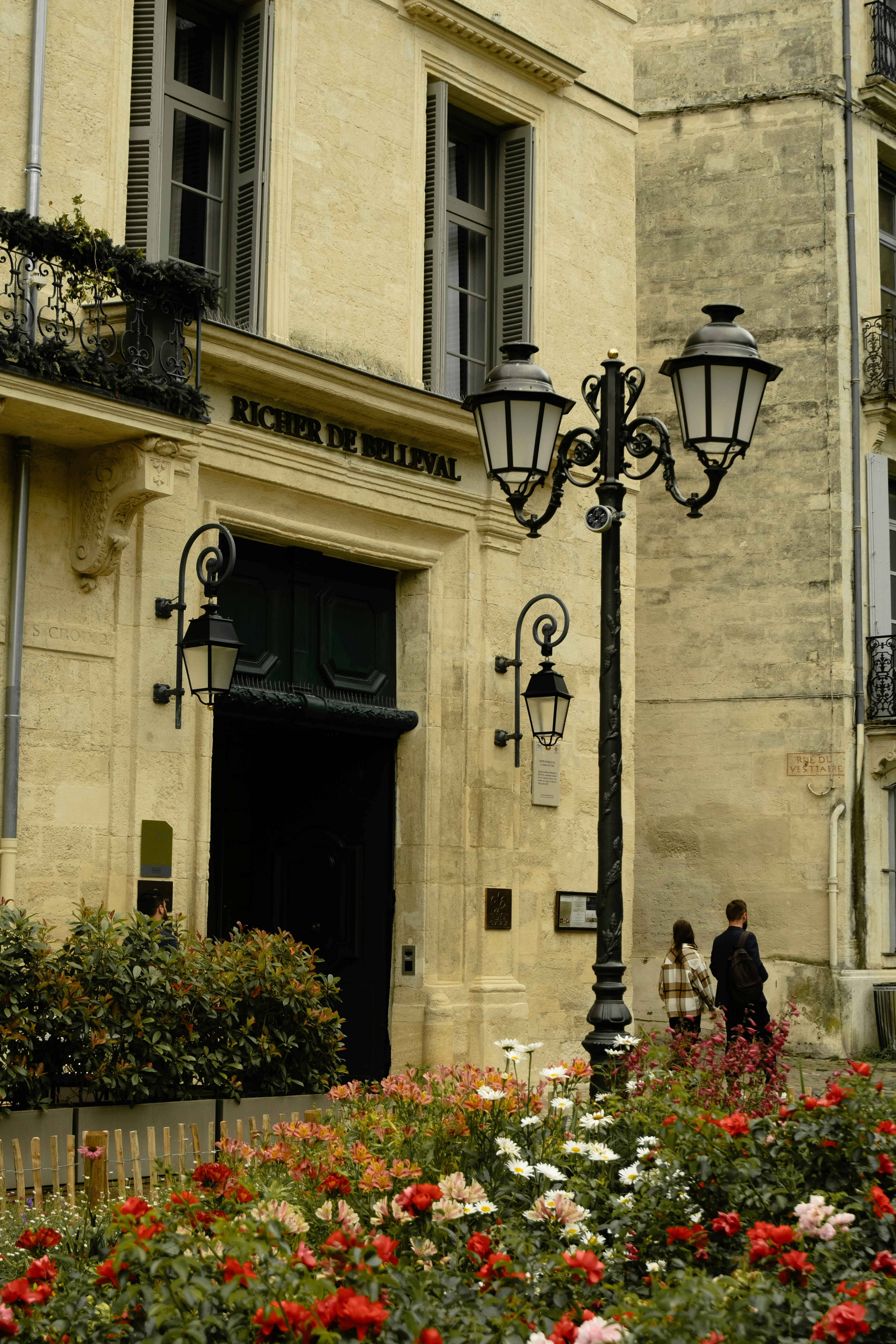 Richer de Belleval doorway framed by lanterns and a bloom-filled foreground