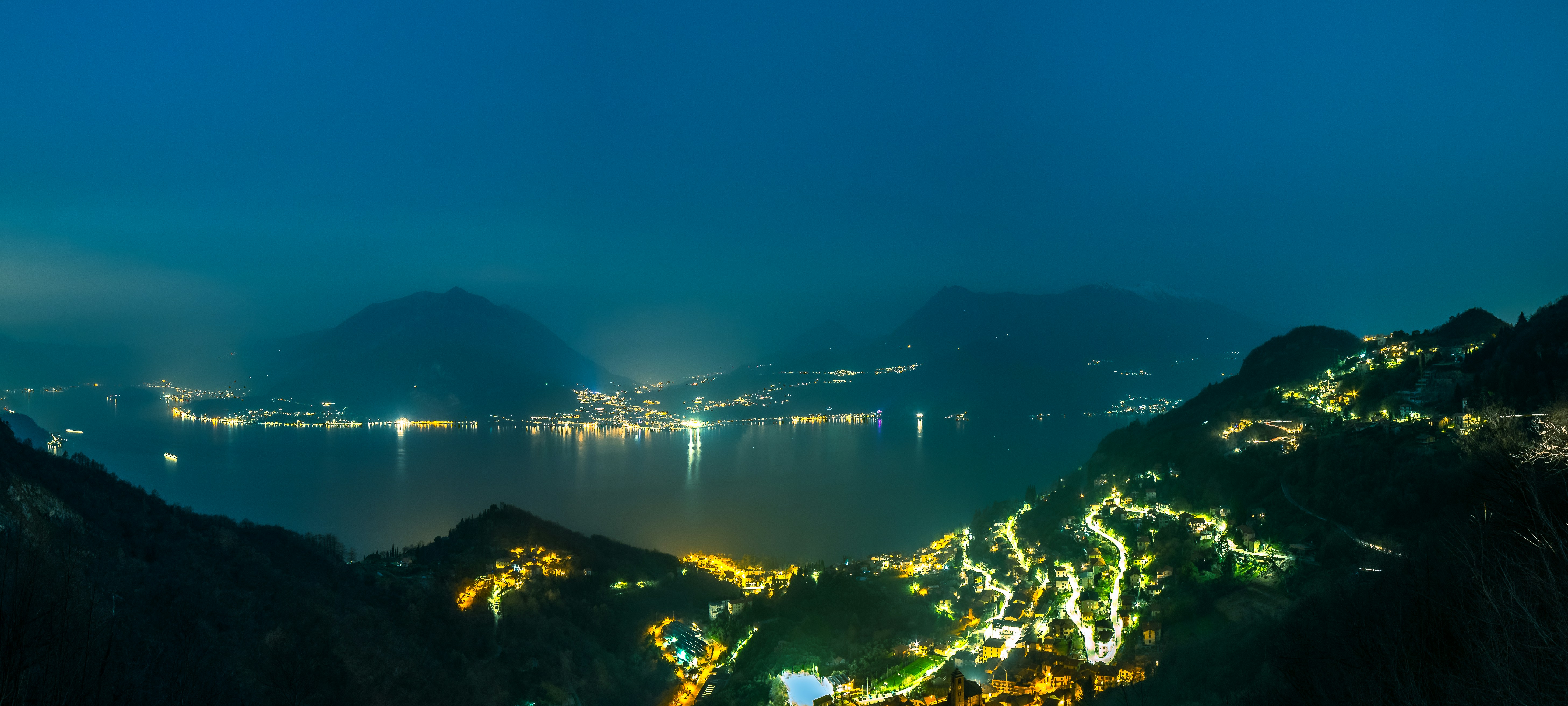 A night view of a city and a body of water photo – Free Esino lario ...
