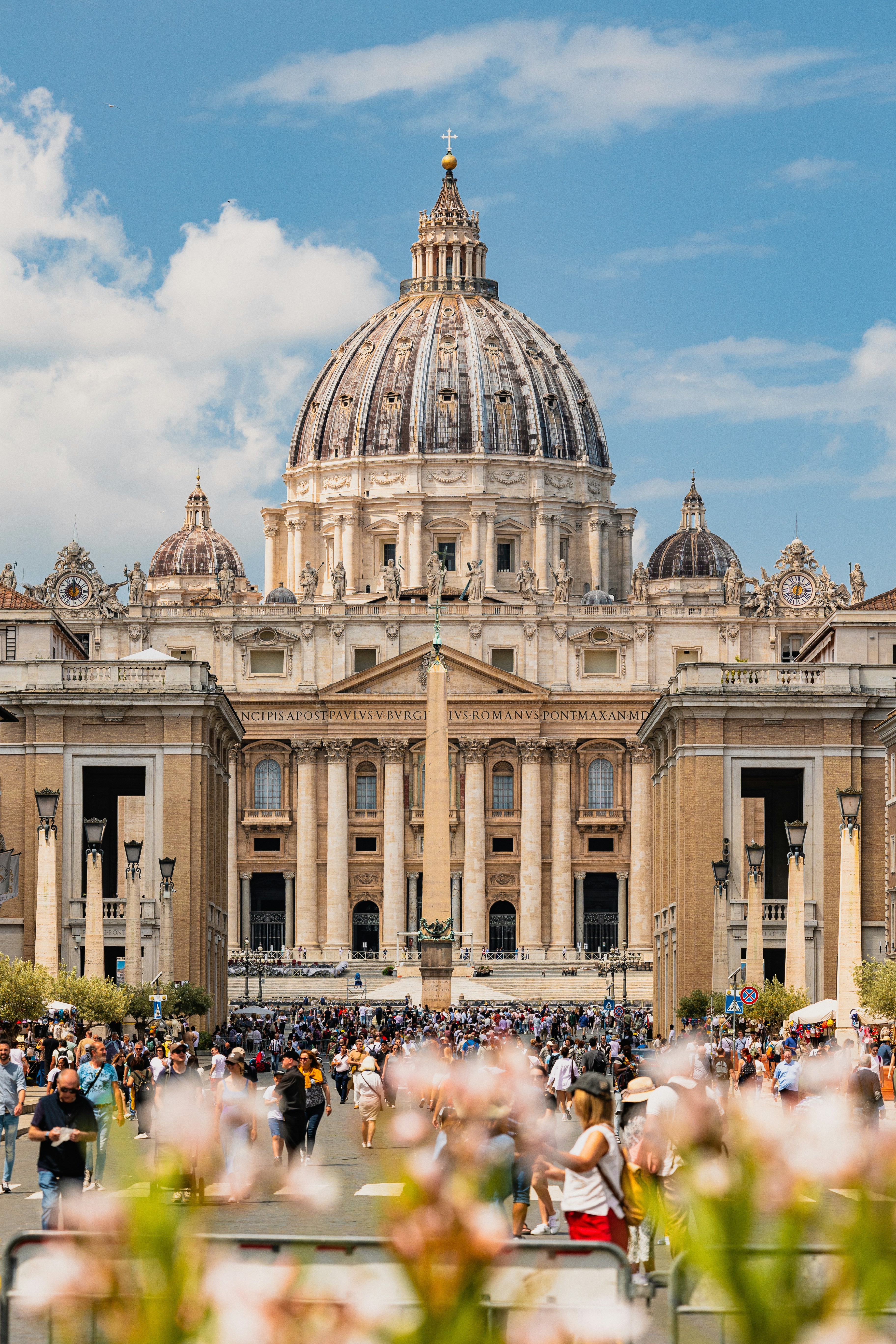 St. Peter's Basilica Framed by the Piazza: A Crowd-Filled Moment Under a Sky-Blue Arch
