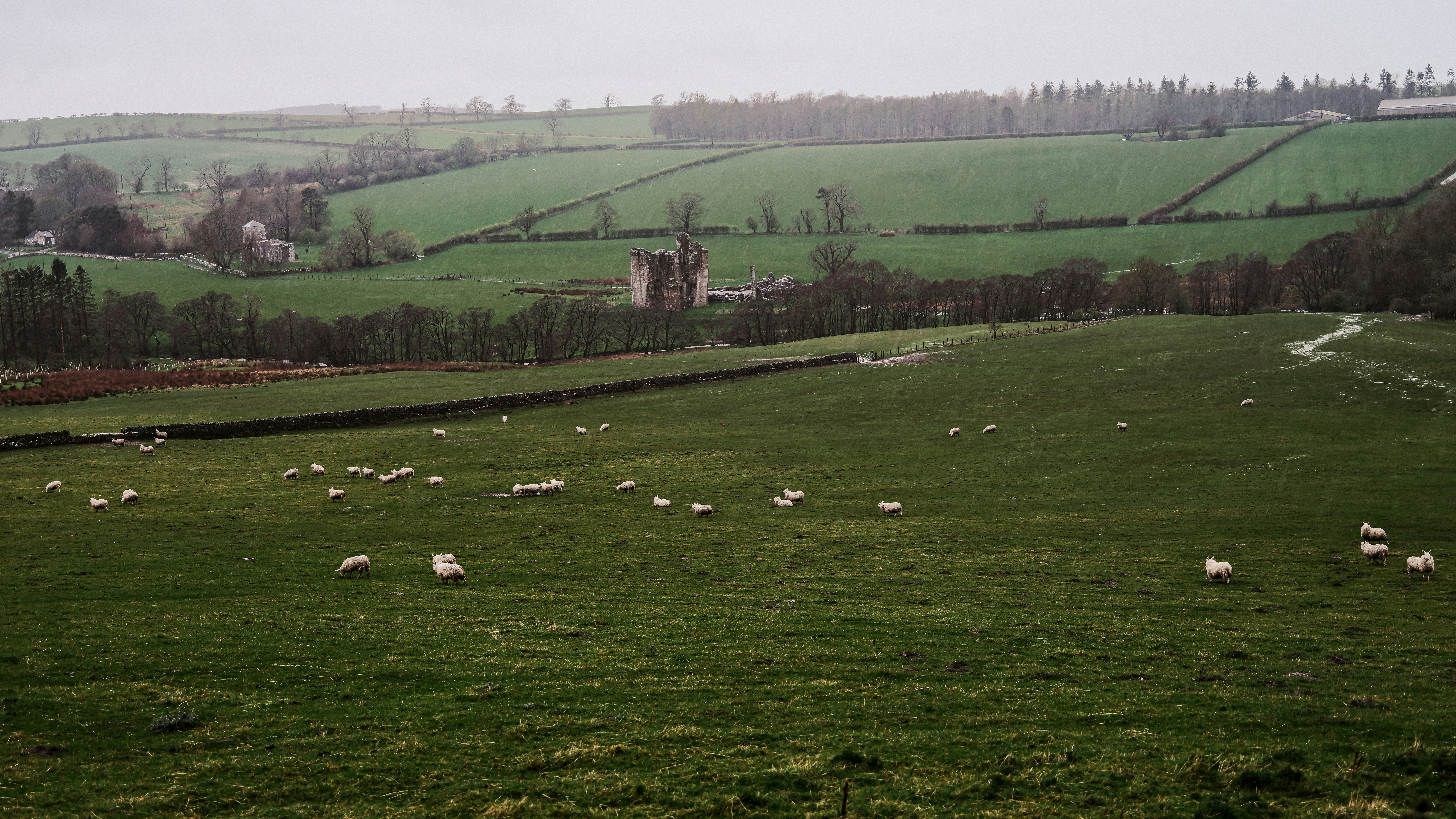 It's pelleting down with rain on the Northumbrian landscape and an ancient ruined mansion.