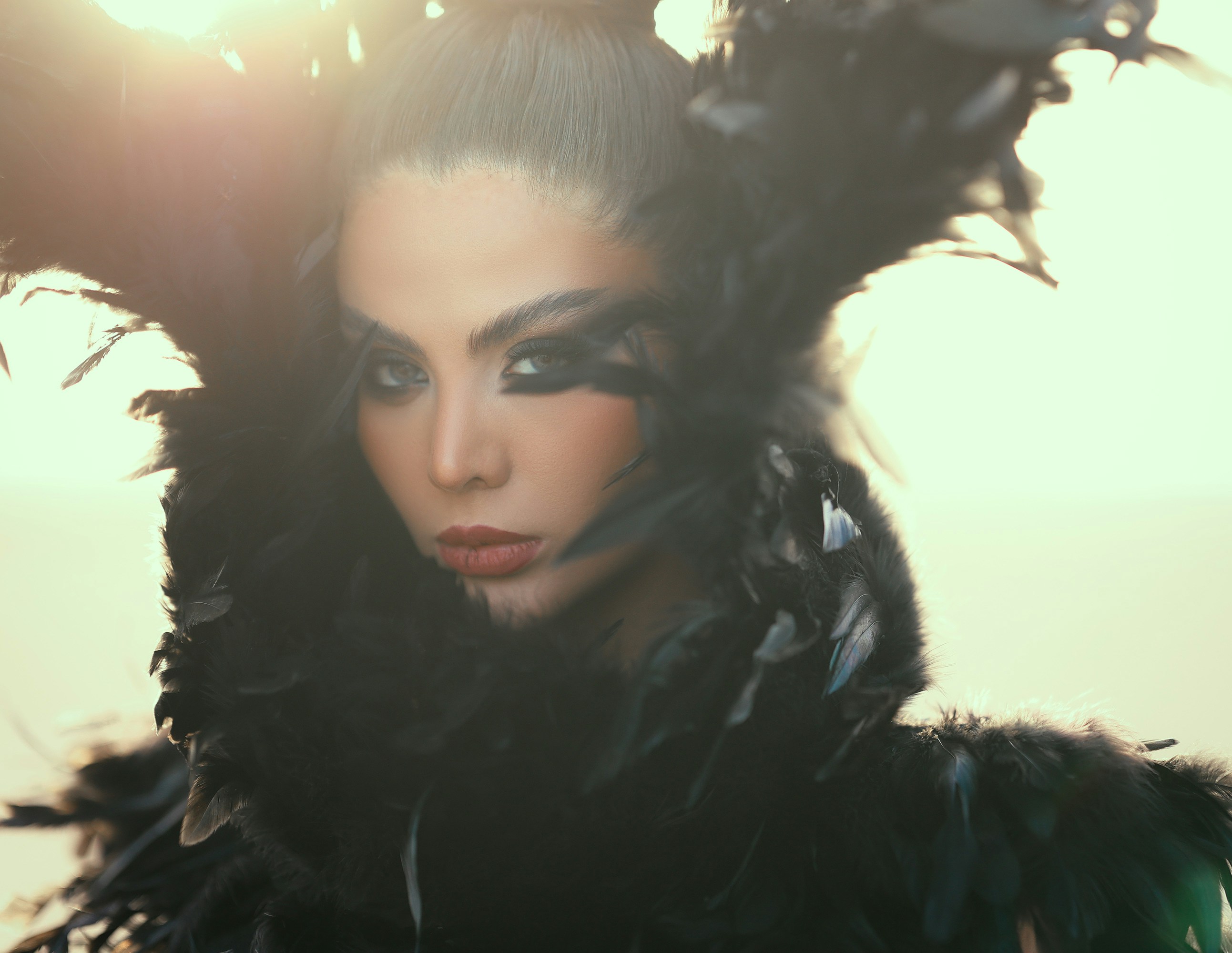 A woman with feathers on her head posing for a picture photo – Free ...