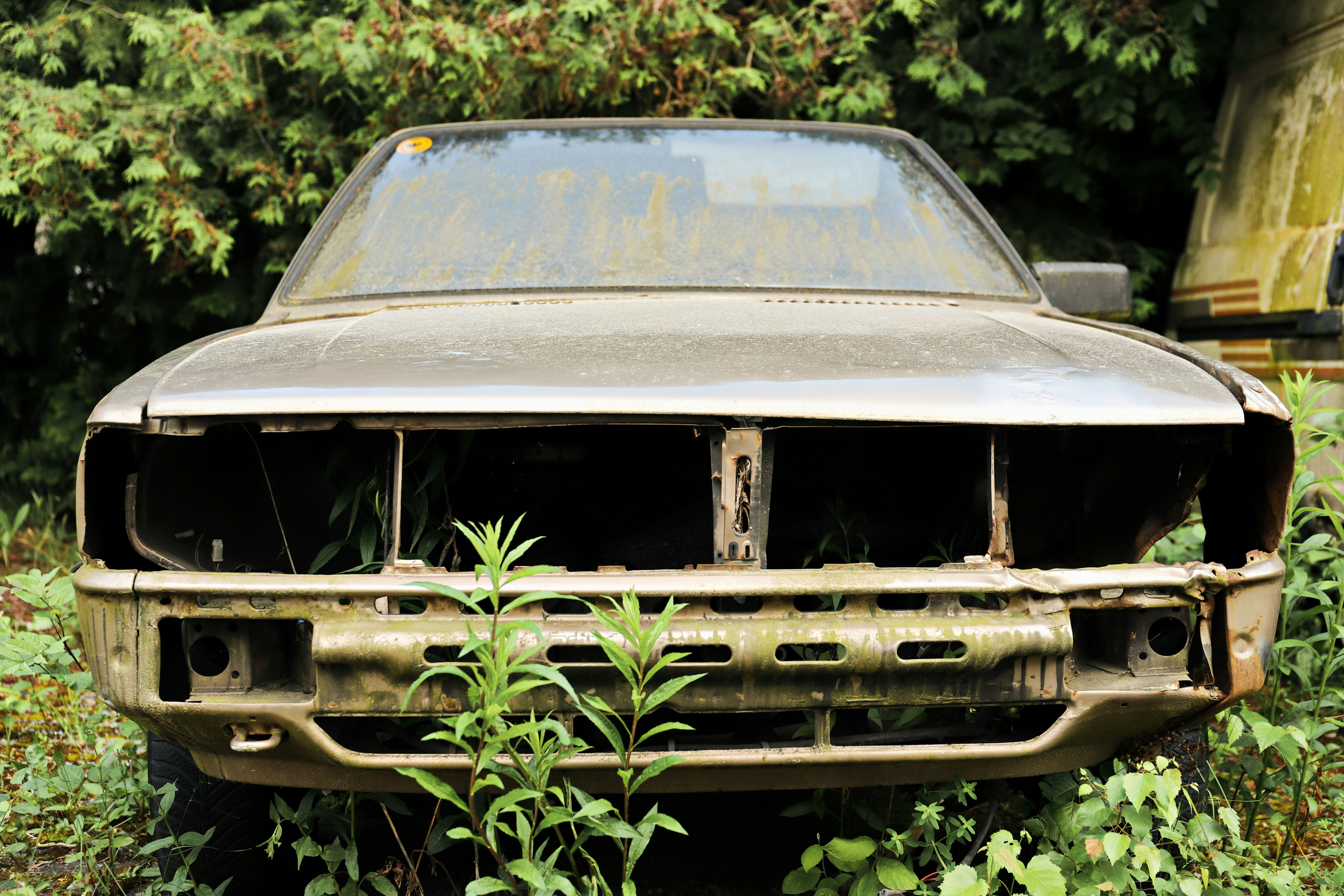 A rusted out car sitting in the middle of a field photo – Free Schrott ...