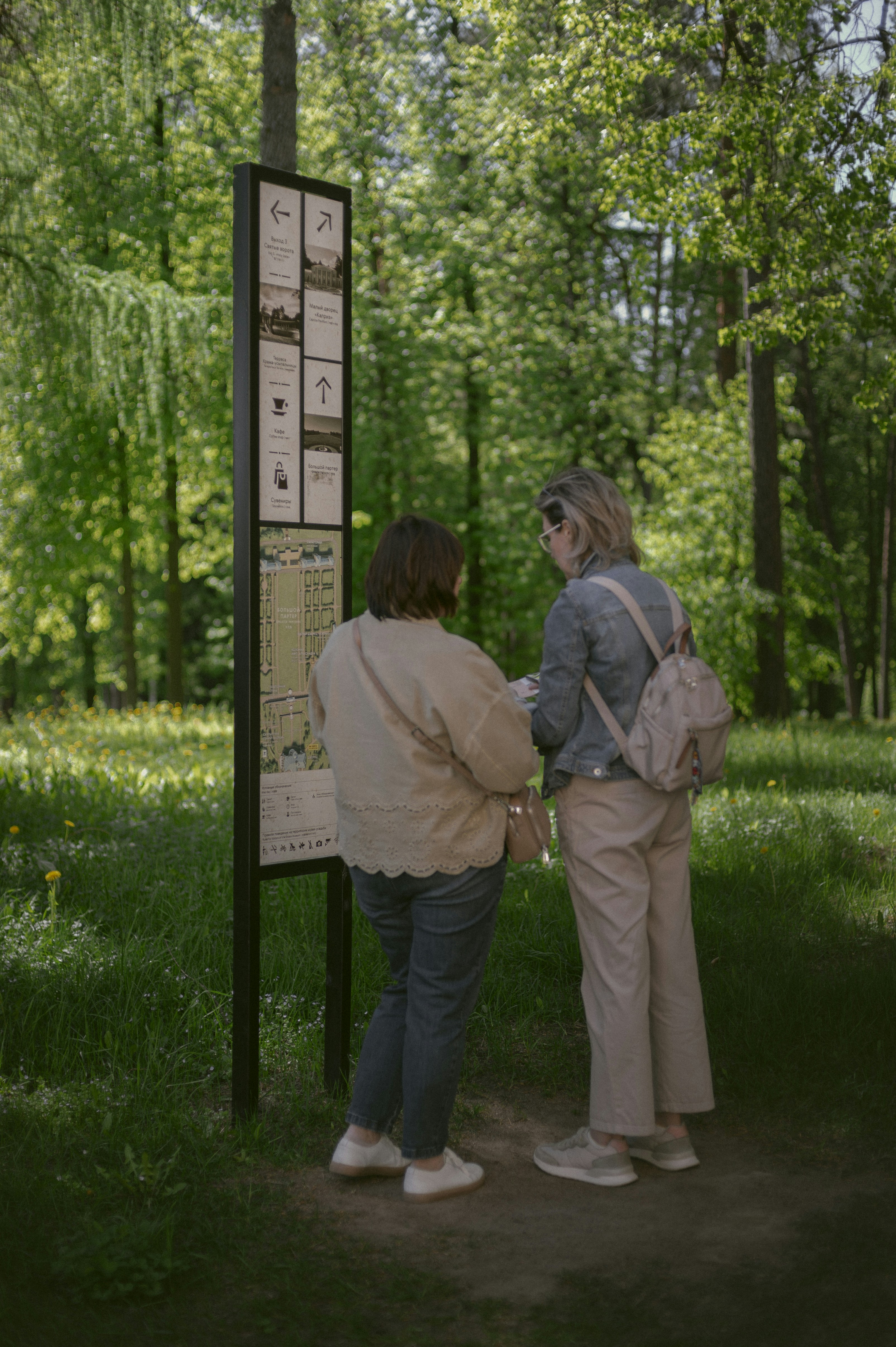 A couple of women standing next to a sign photo – Free Архангельское ...