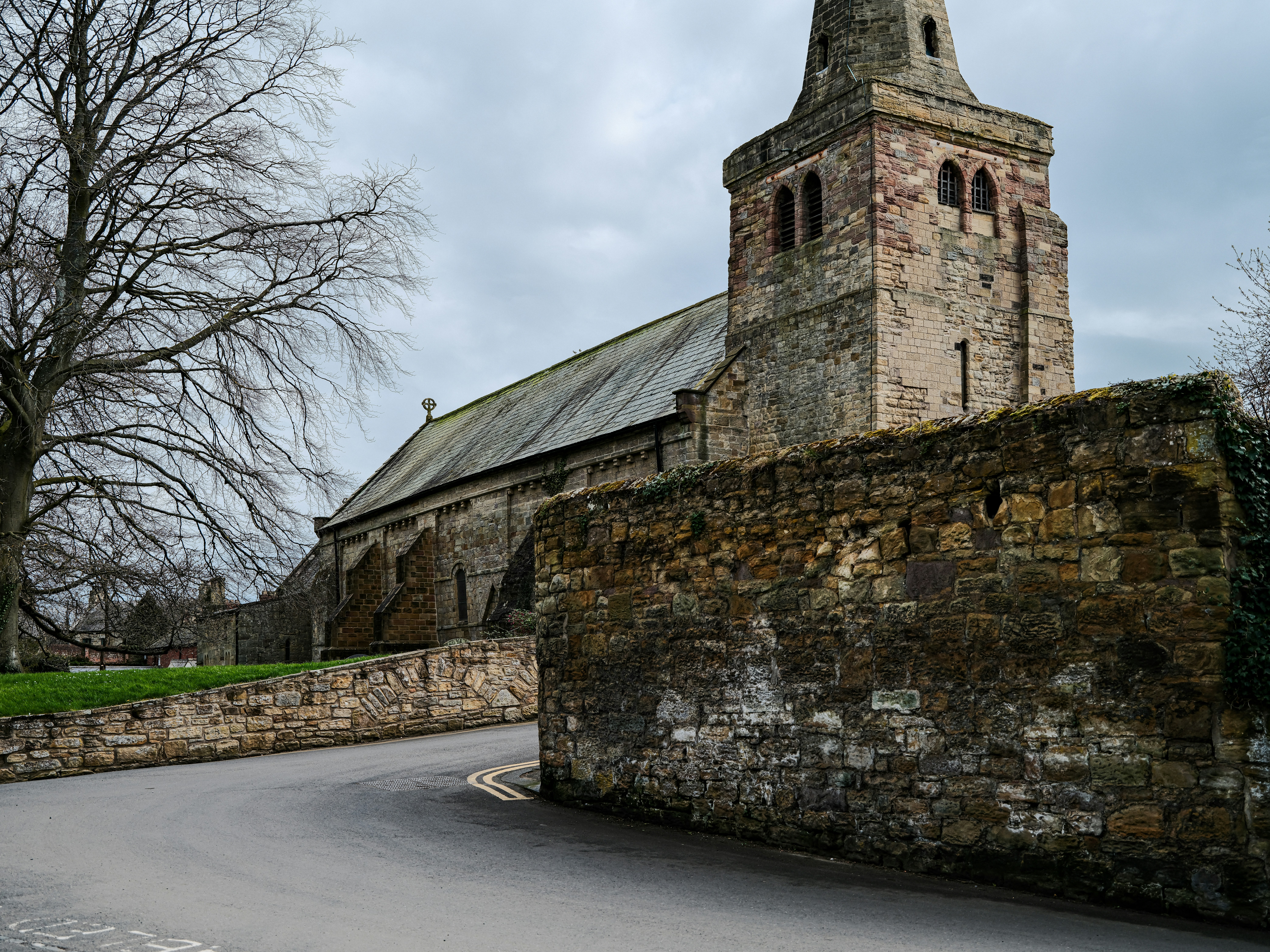 An old stone church with a steeple on a cloudy day photo – Free ...