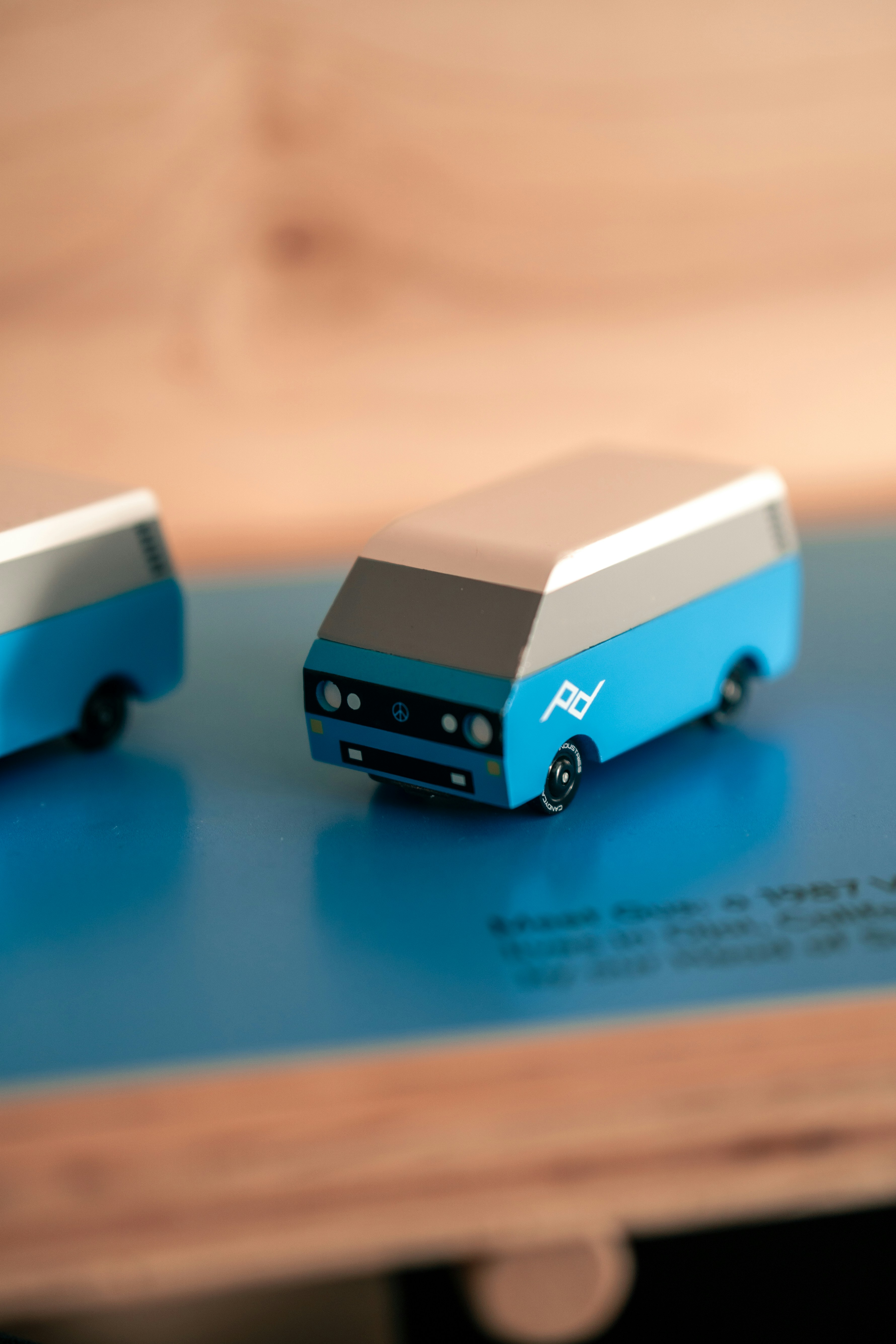 Front-Row Focus: Close-Up of a Tiny Blue Toy Van on a Lively Surface