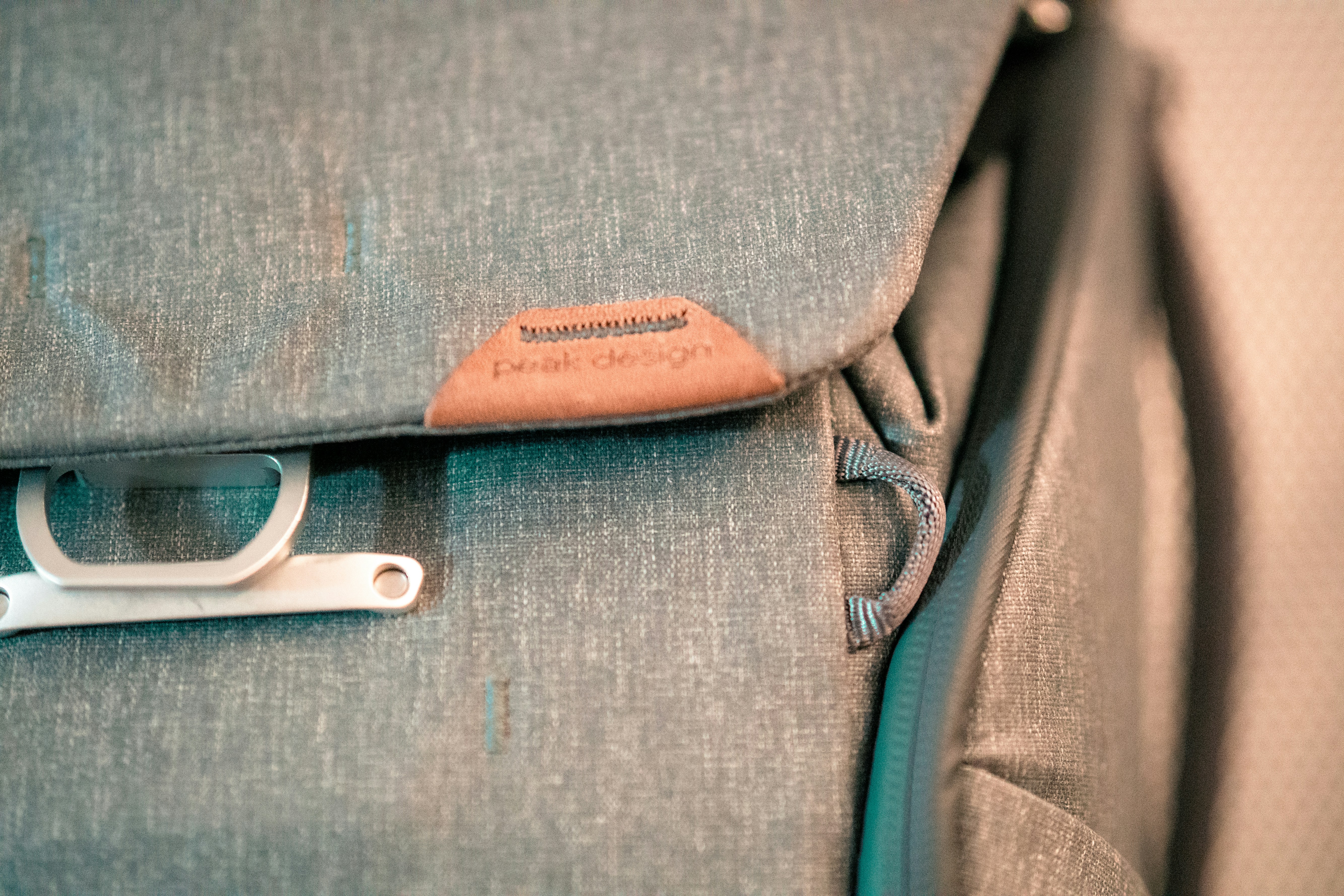 Close‑up of a denim backpack pocket and metallic zipper pull