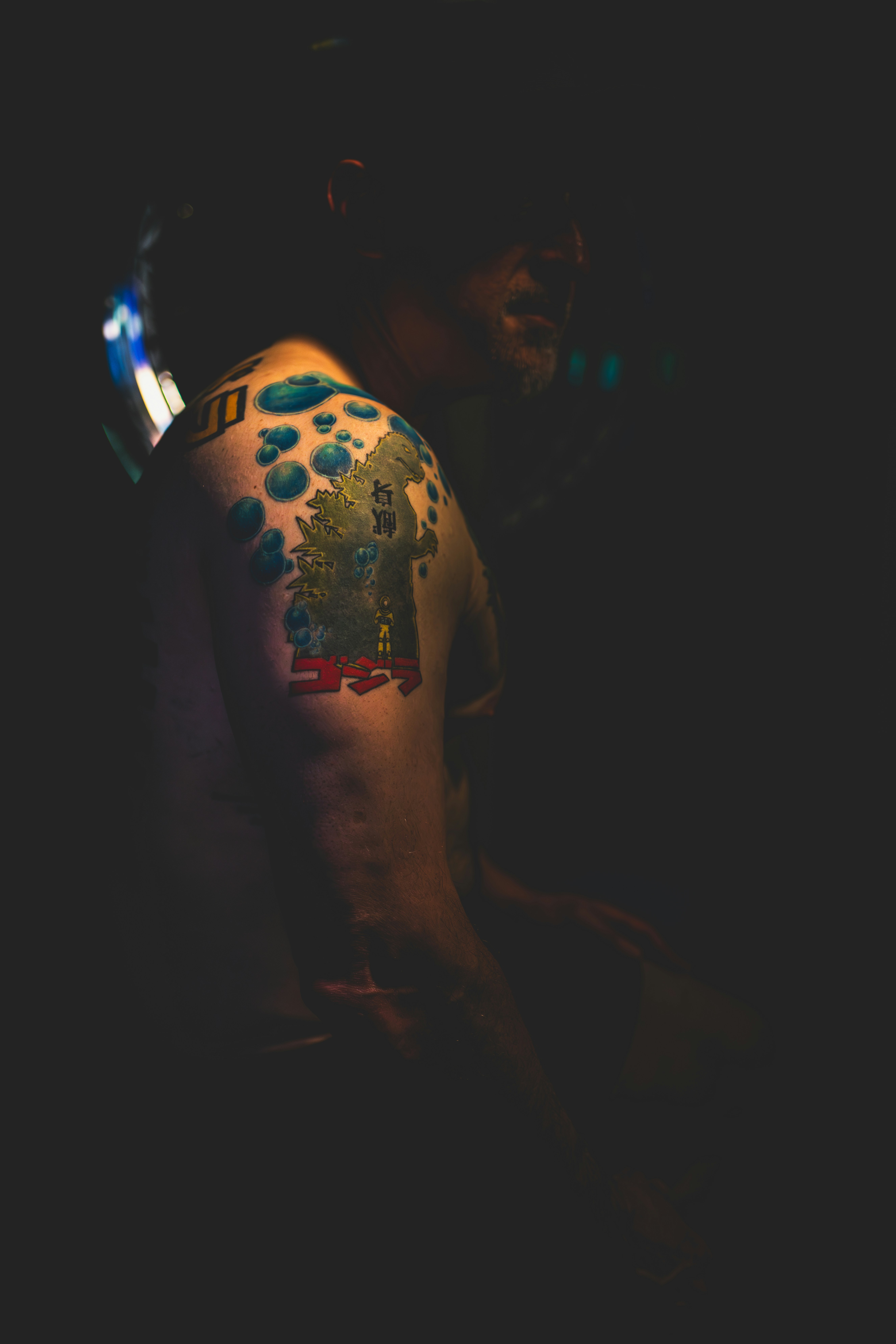 Low-Light Ink: Tattooed Shoulder Emerges from the Shadow