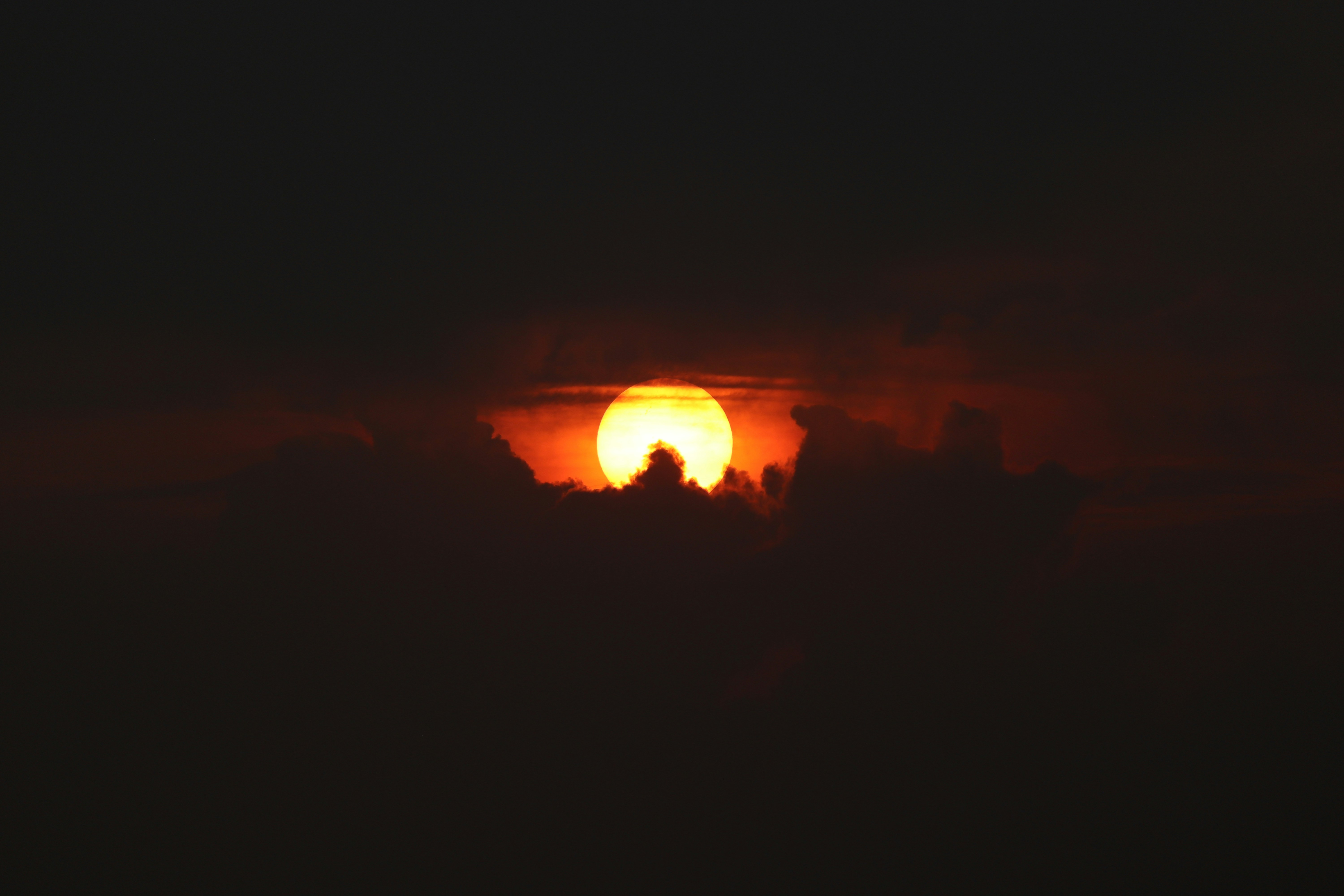 Sun Peeks Through Ember Clouds at Dusk