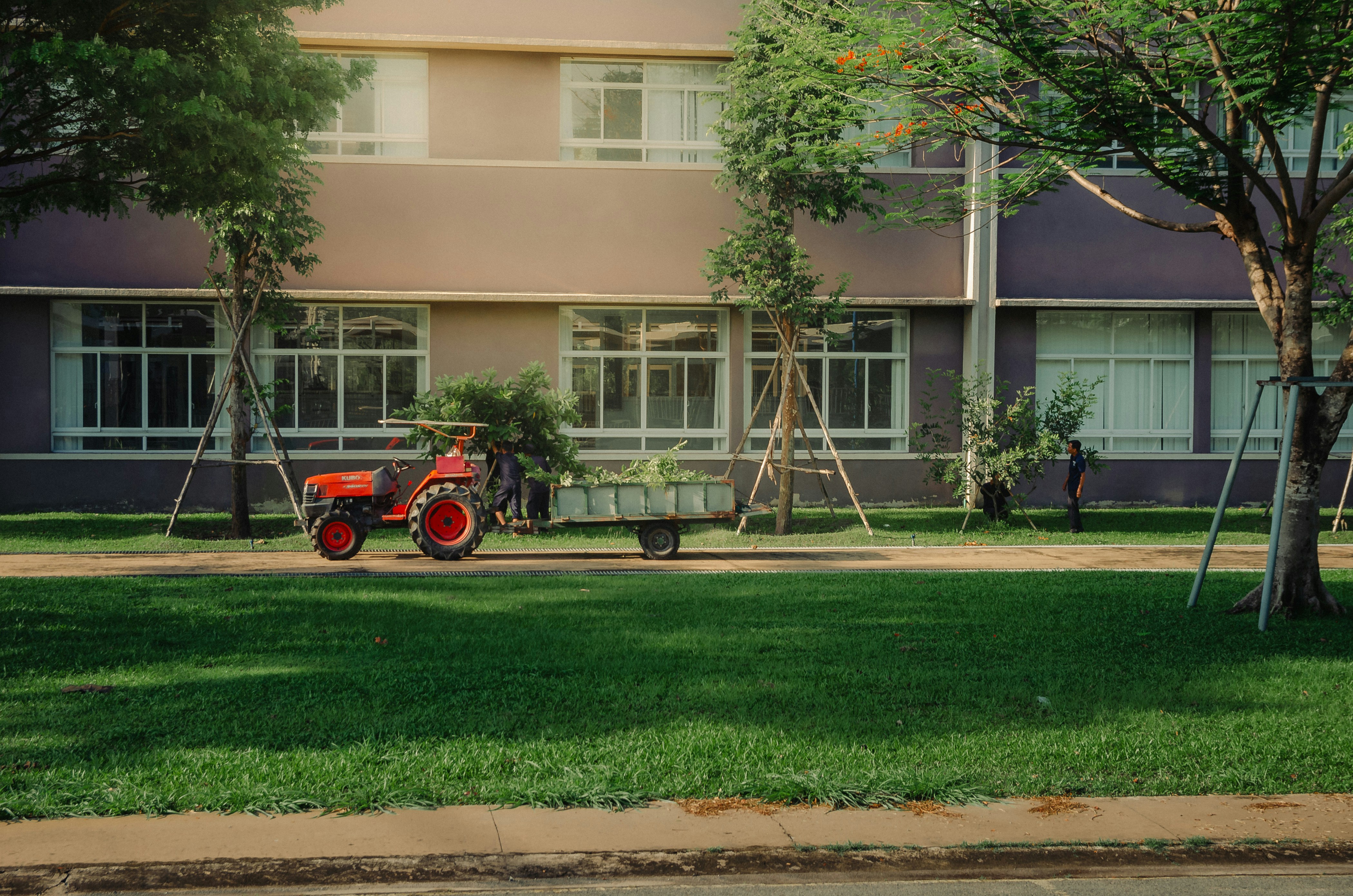 a red tractor parked in front of a building
