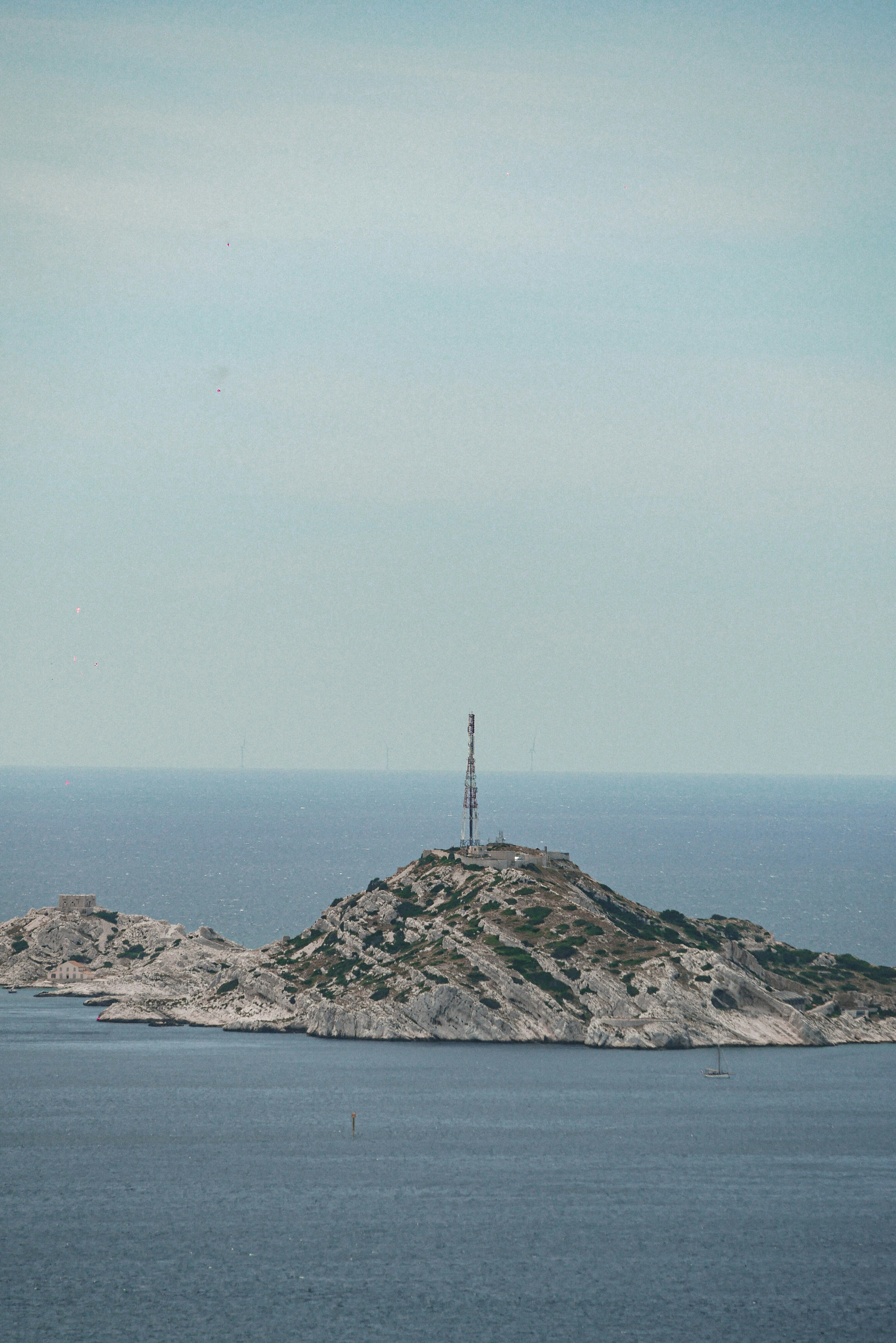 Isolated Sentinel: Craggy Island Crowned by a Weathered Antenna